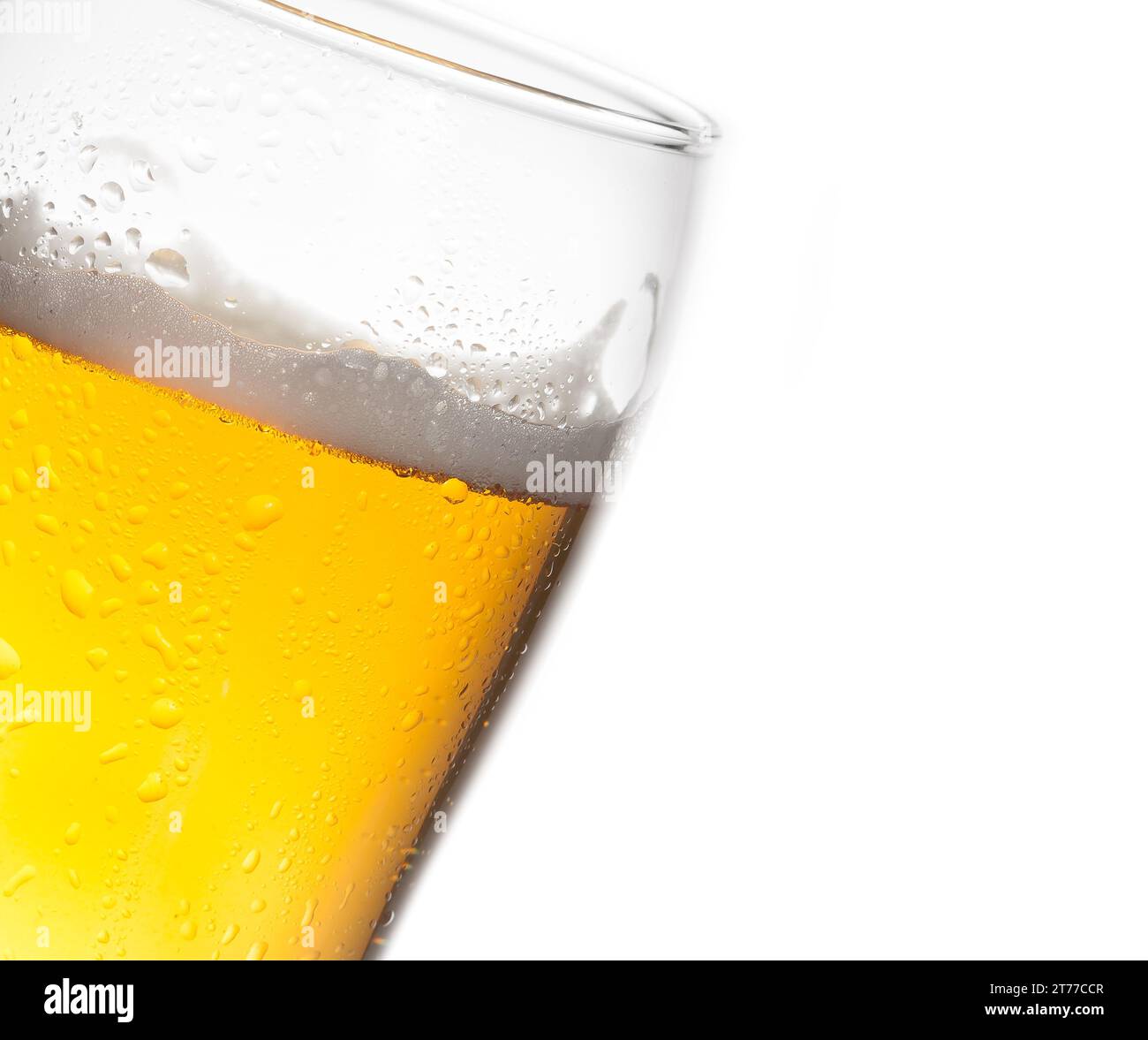 detail of tilted glass of fresh beer with drops on white background ...
