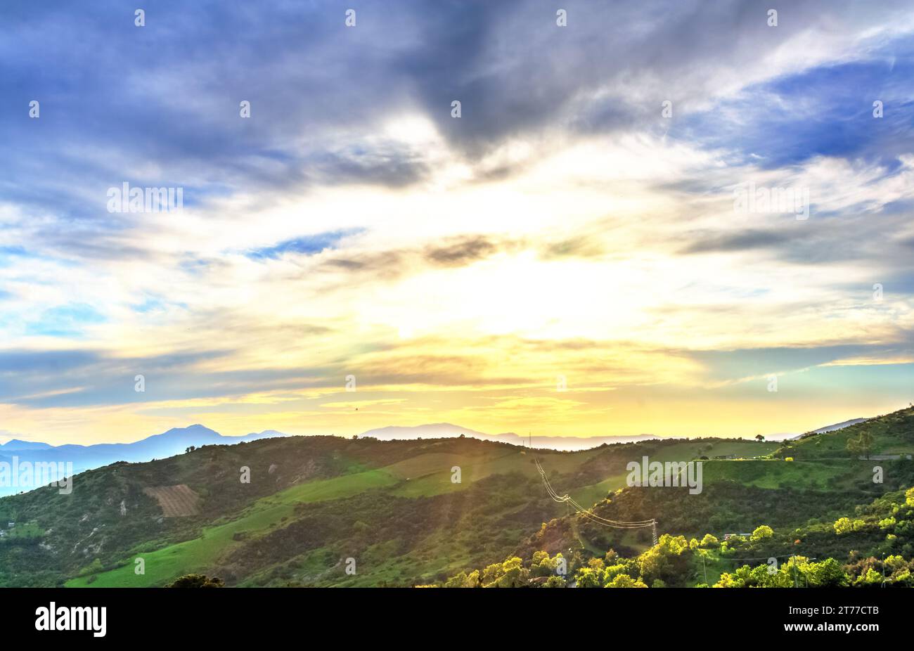sunset scene with sun fall behind the clouds and mountains in ...