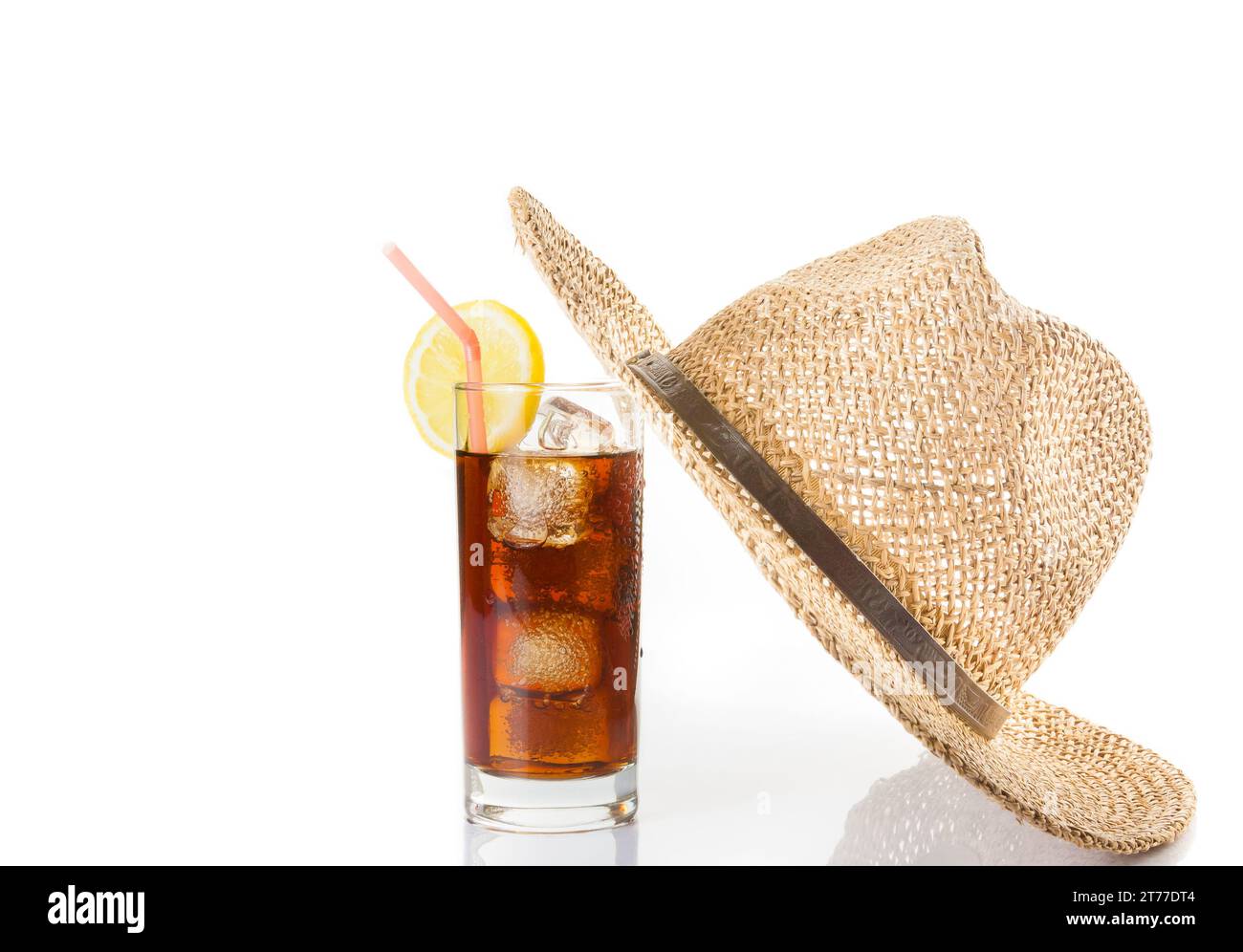 glass of fresh coke with straw near summer hat on top and white ...