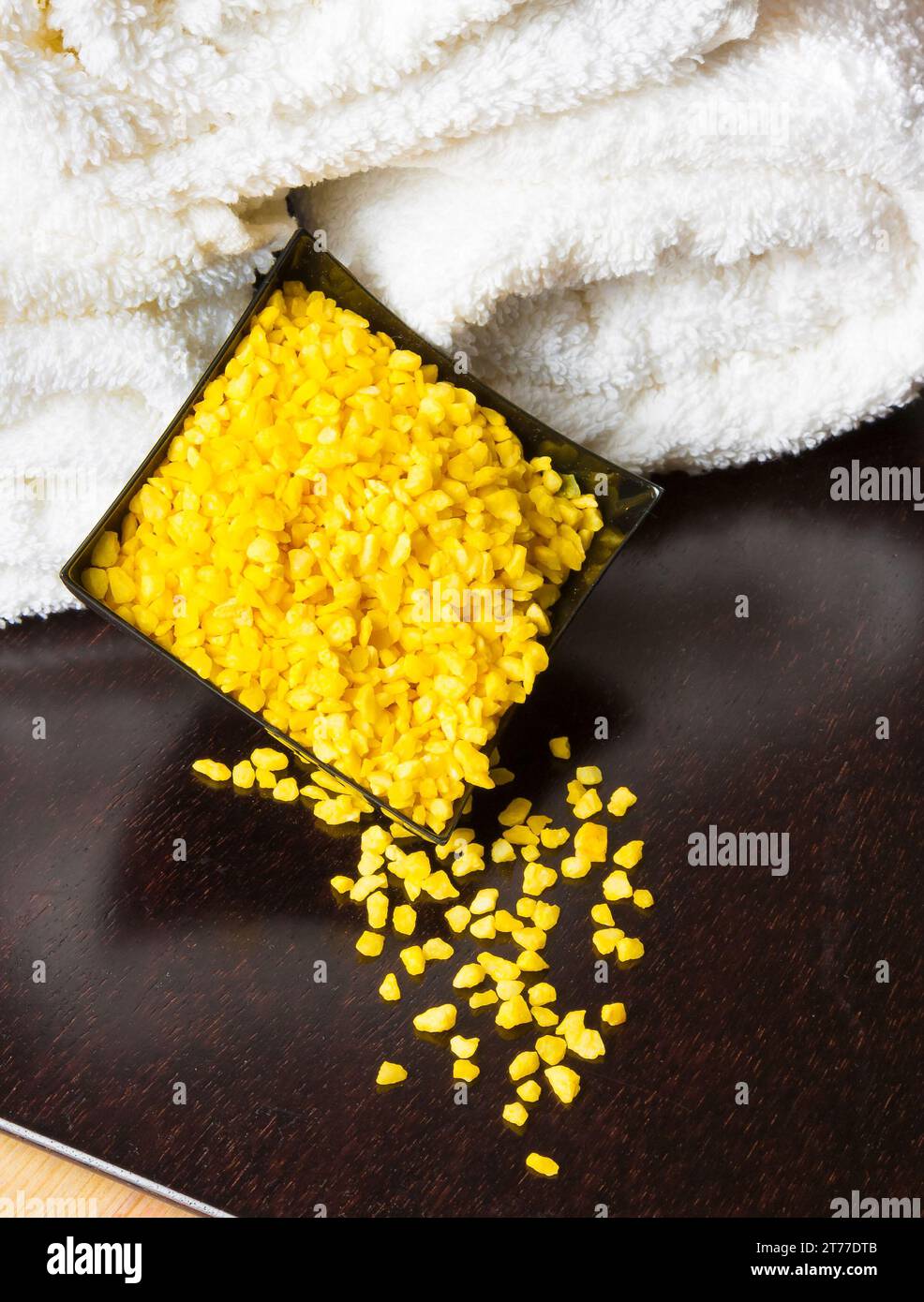 Spa massage border background with towel stacked and yellow sea salt on ...
