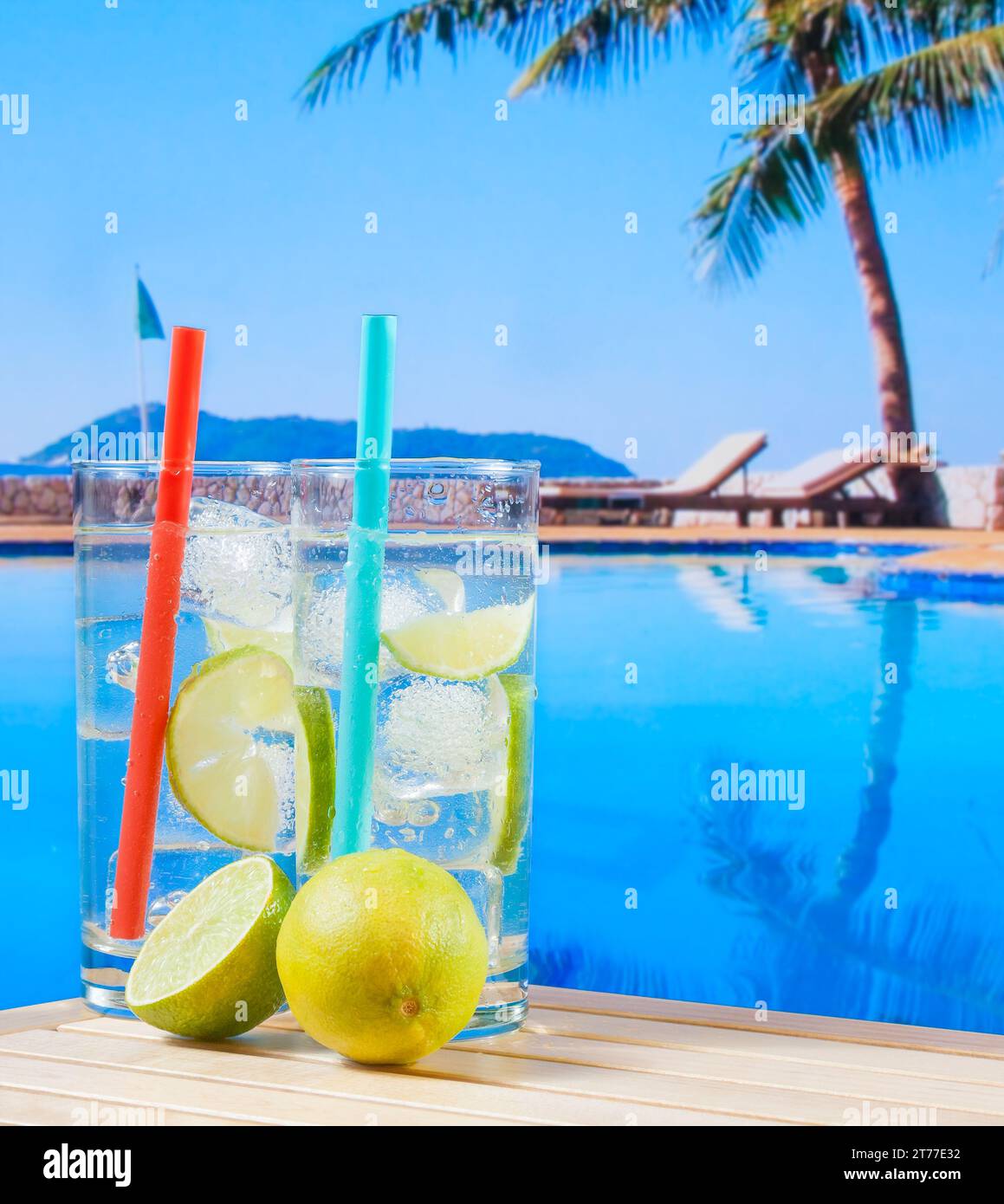 two glasses of cocktail with lime slice on blur swimming pool ...