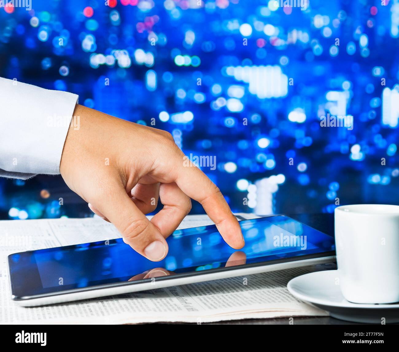 business man touch digital tablet on business newspaper near window ...