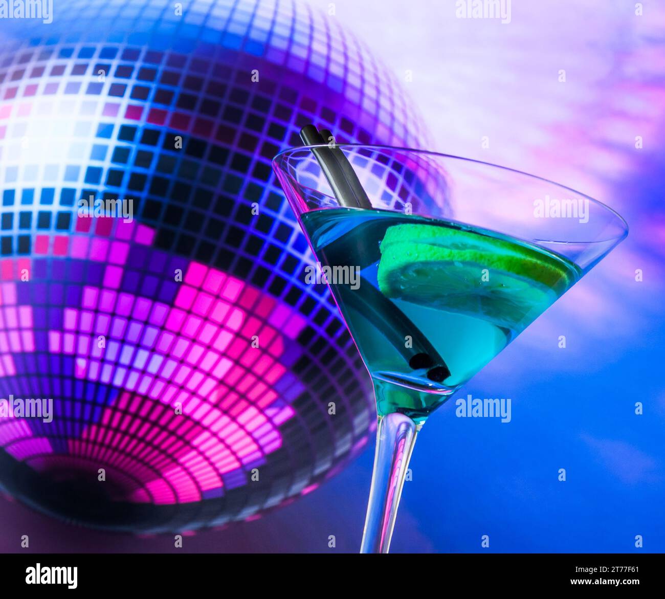 blue cocktail with sparkling disco ball background with space for text ...