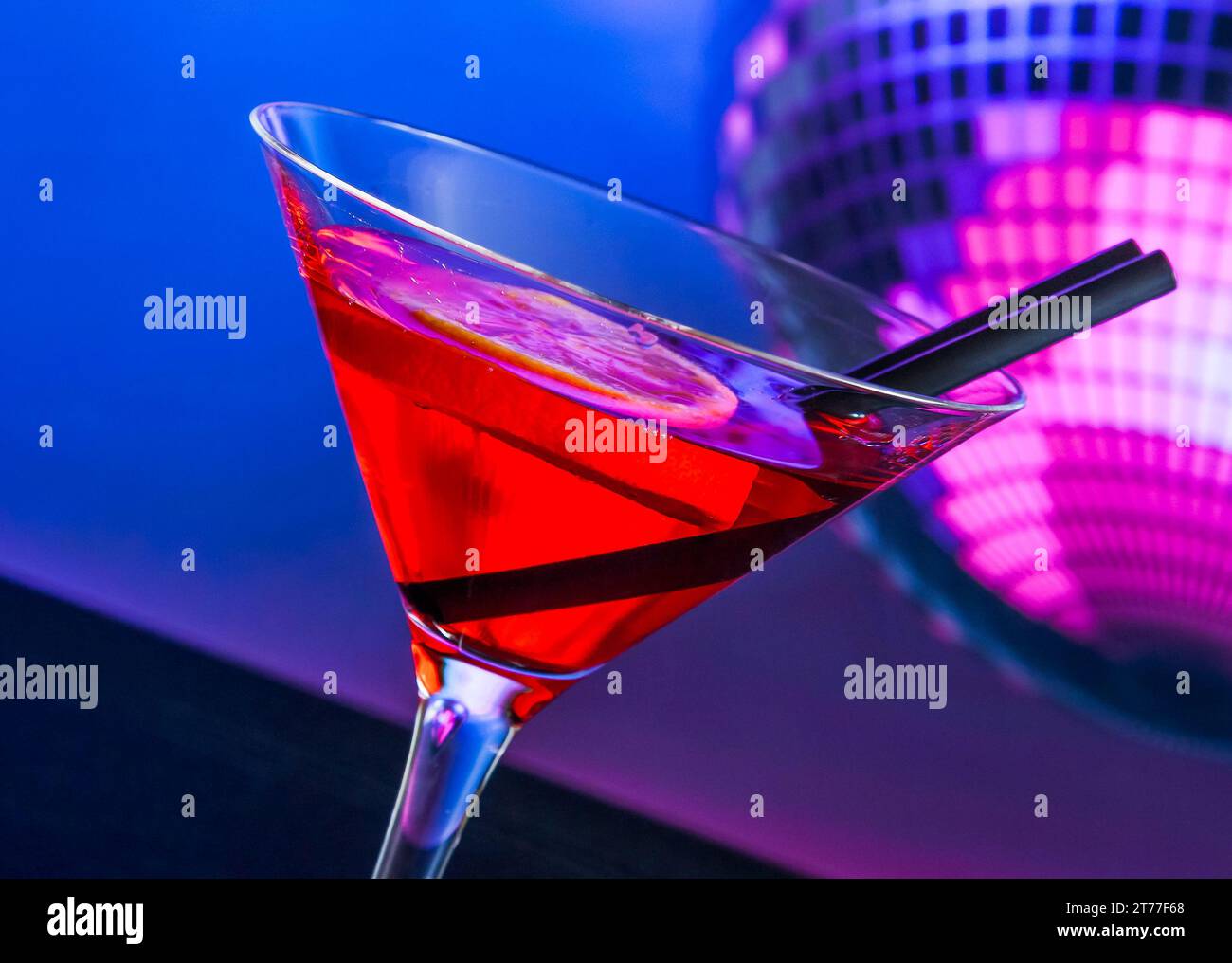 red cocktail with sparkling disco ball background with space for text ...