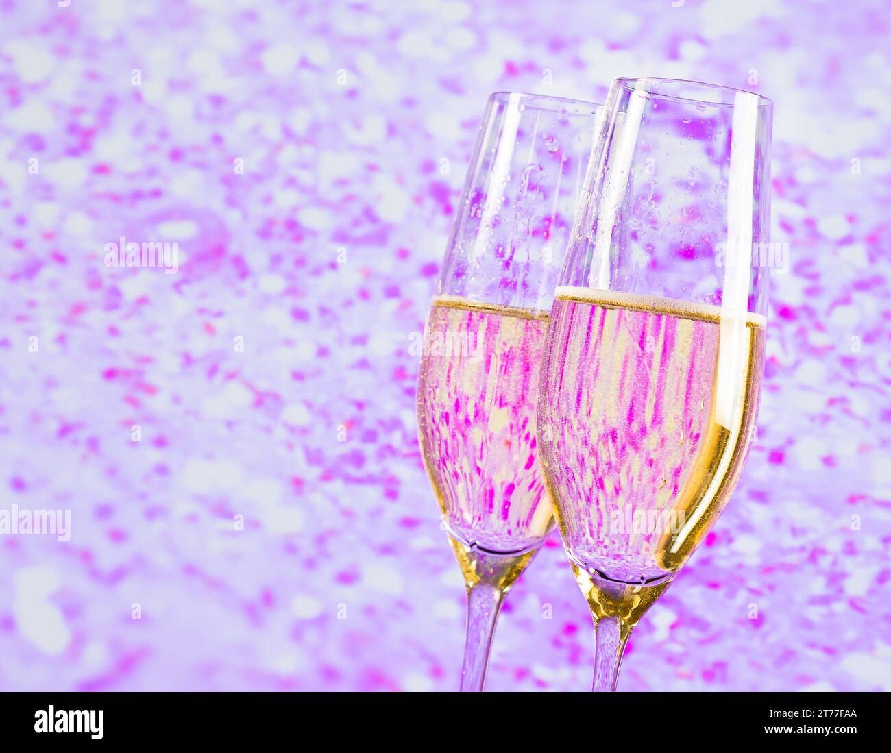 champagne flutes with gold bubbles on blur violet tint light background ...