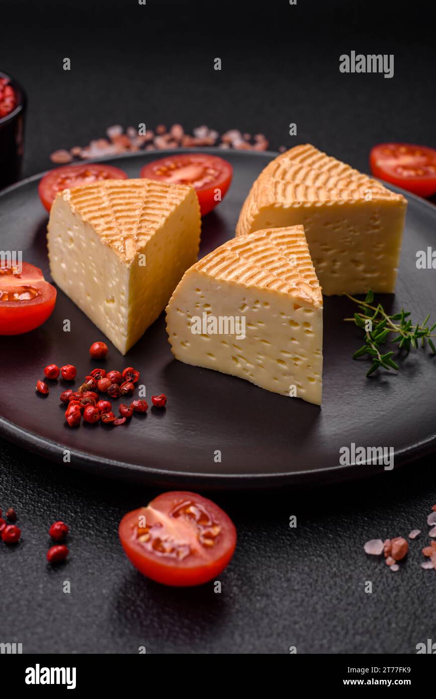 Delicious hard craft cheese made from cow or goat milk on a dark ...