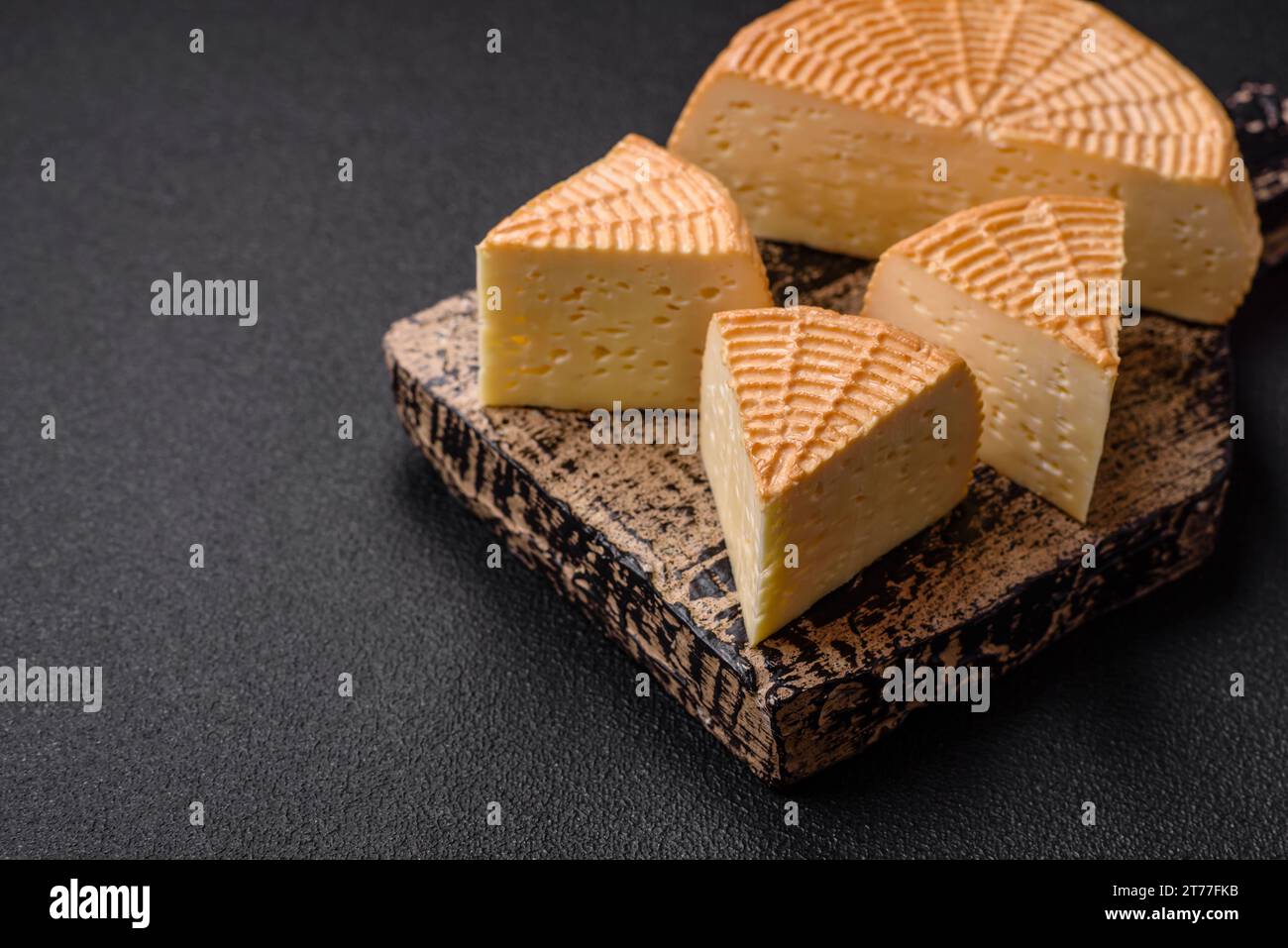 Delicious hard craft cheese made from cow or goat milk on a dark ...