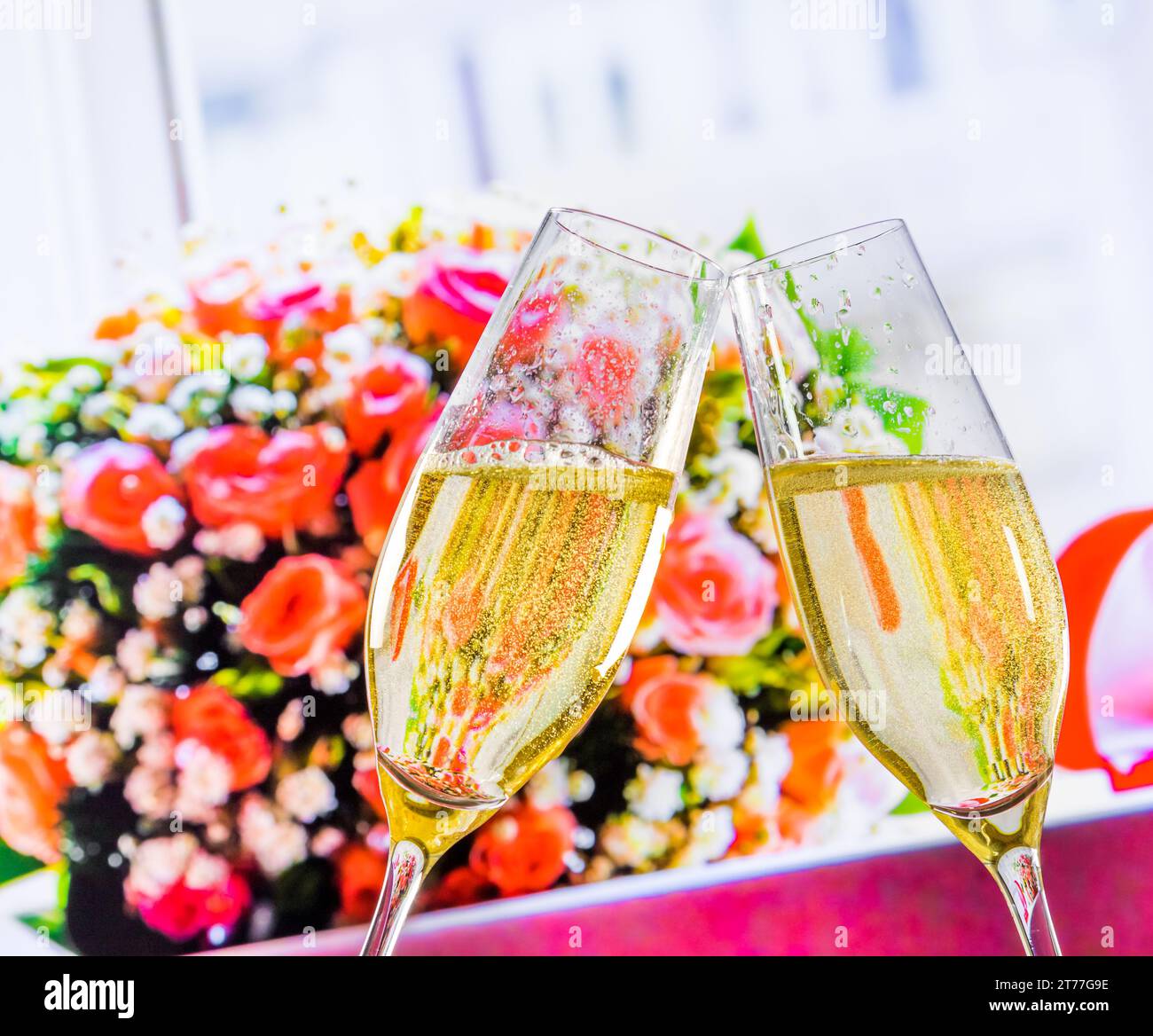 champagne flutes with golden bubbles make cheers on wedding flowers ...