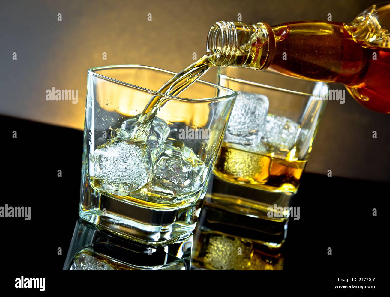 barman pouring whiskey in front of whiskey glass on warm light and ...