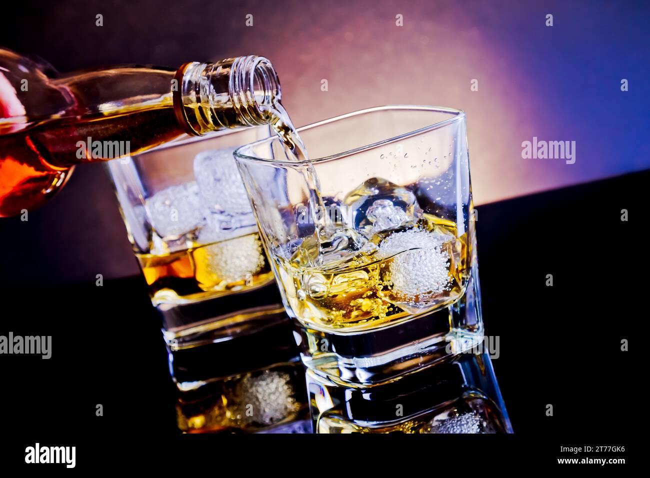 barman pouring whiskey in front of whiskey glass on light tint blue ...