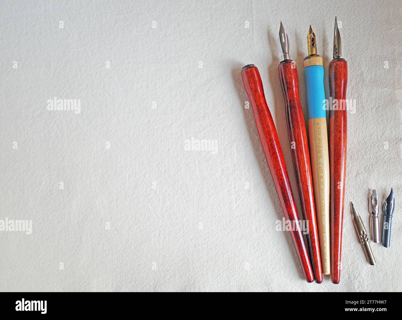 Dip pens with holders lying on handmade paper Stock Photo - Alamy