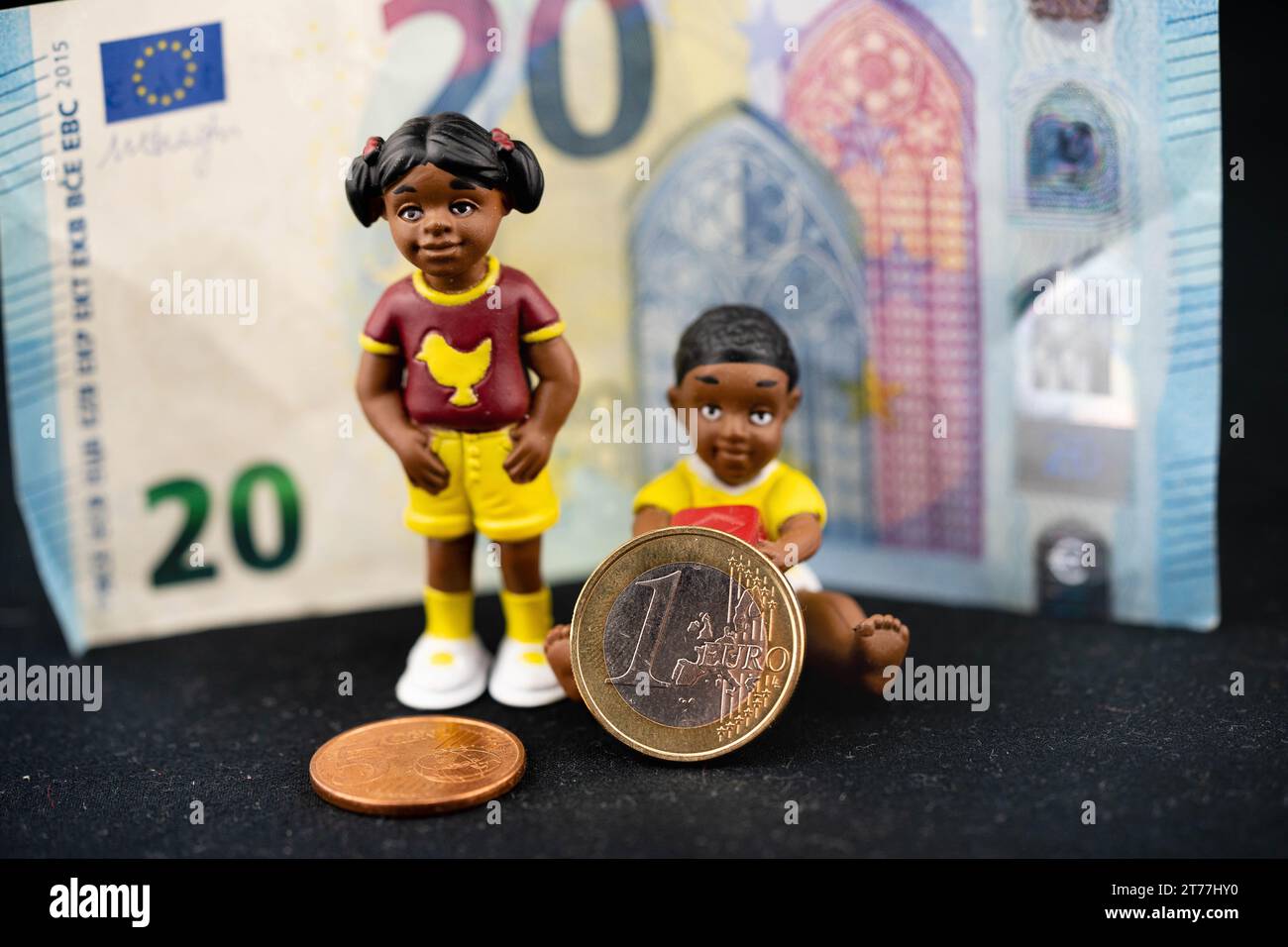 children's plastic figures with euro coins and 20 Euro bill, symbolic ...