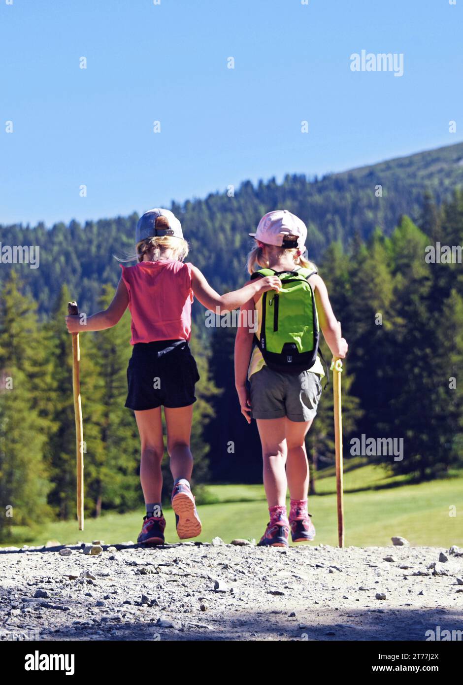 two little girls hiking together on a hiking trail, rear view, France ...