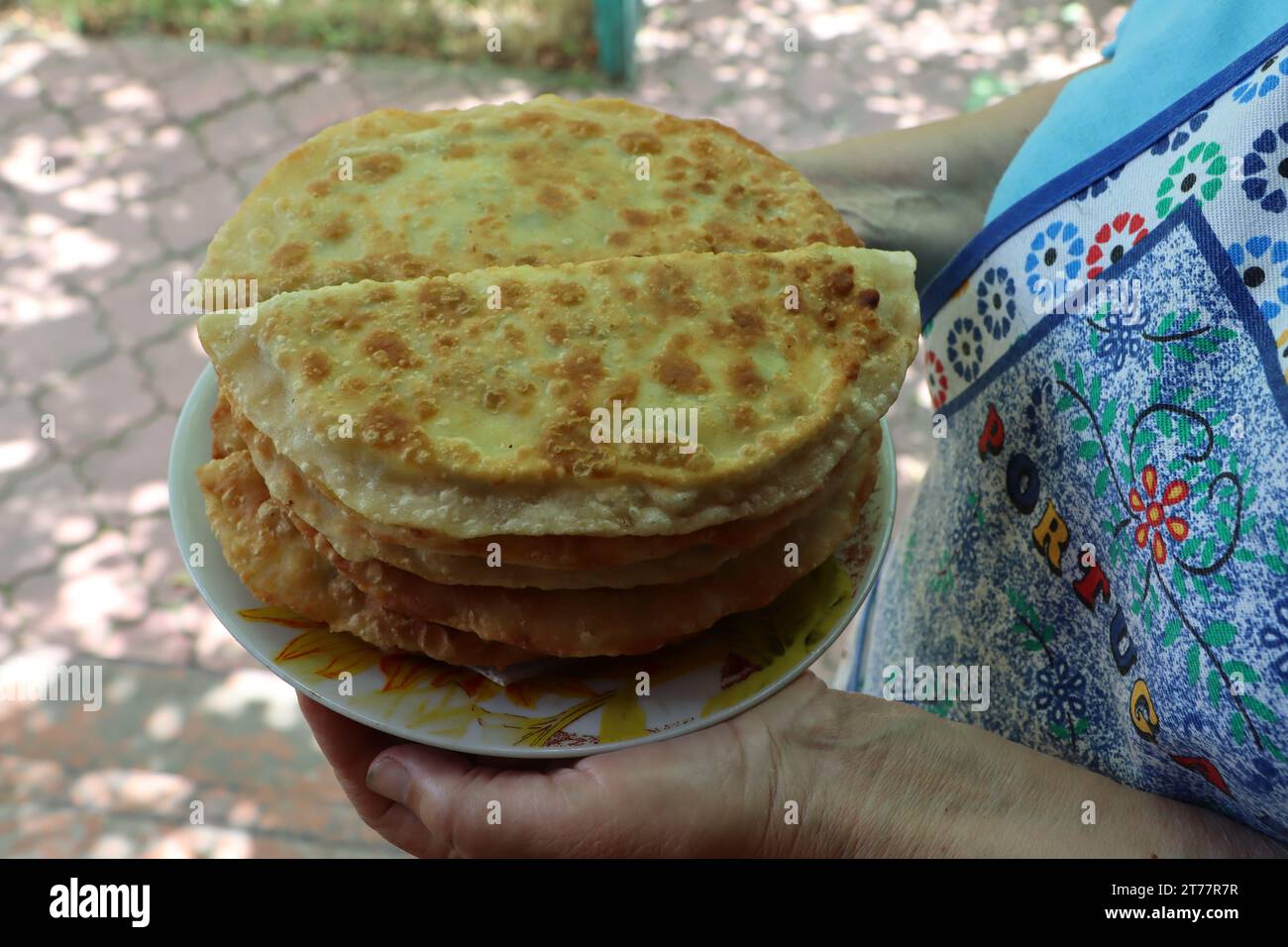 Grandmother holding a full plate of pasties in her hands, traditional ...