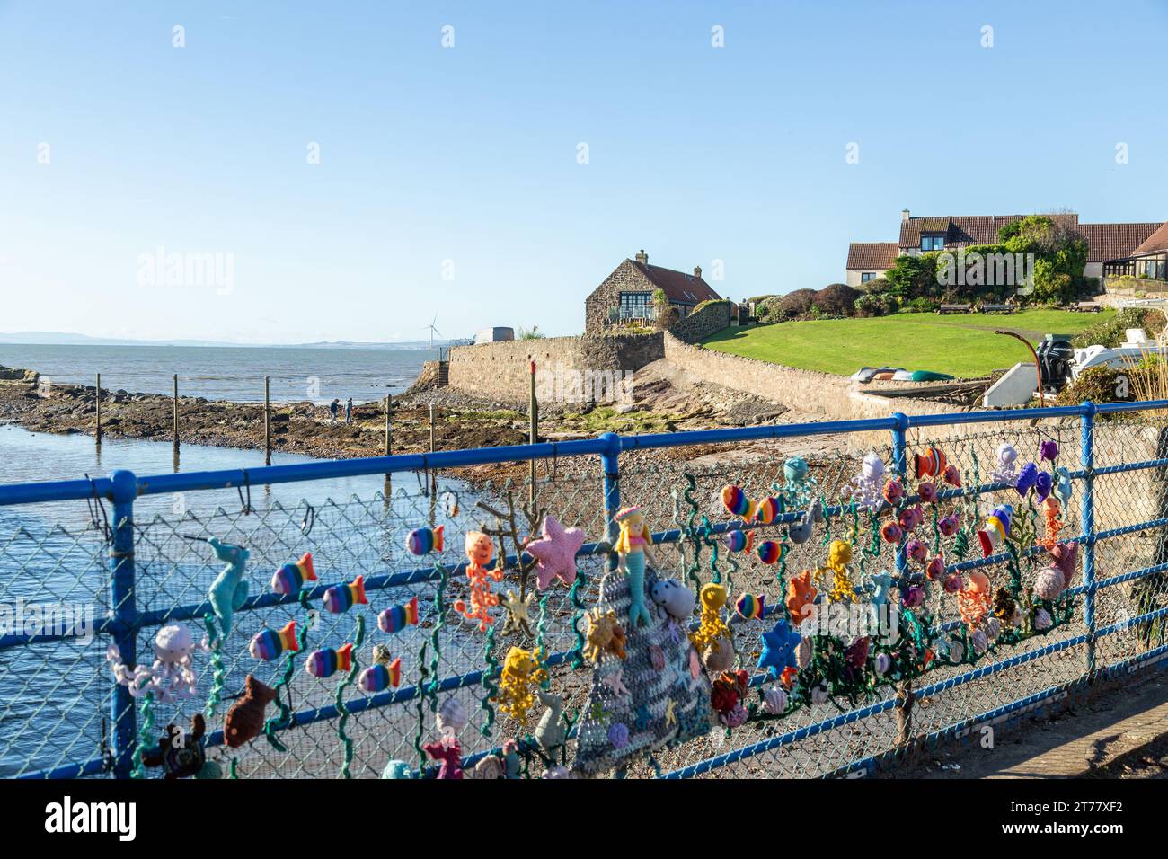 Colourful knitting in the shape of fish and marine life on a fence at ...