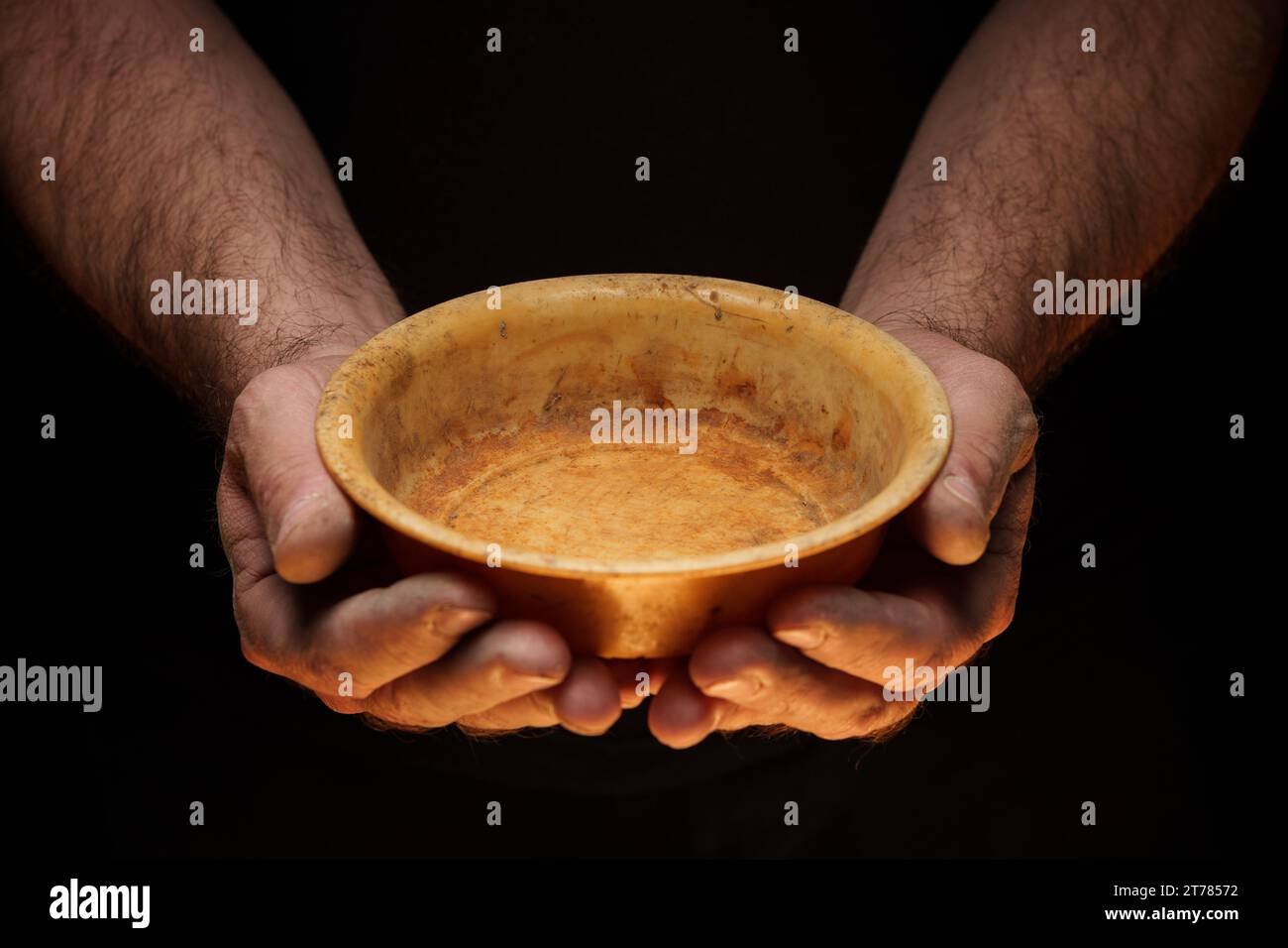 Male hands holding empty plate on dark background, lack of food, hunger ...