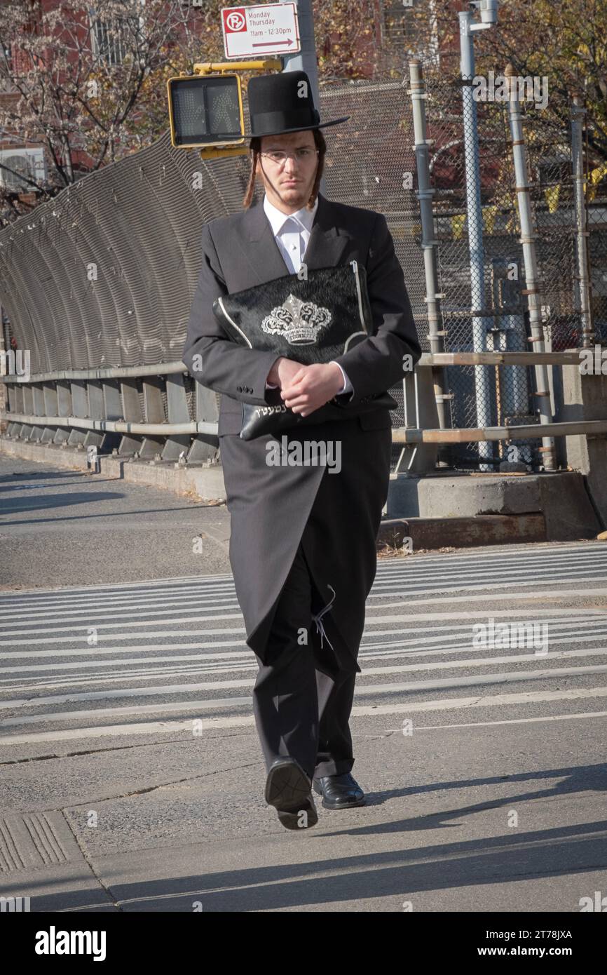 An orthodox Jewish man returns from morning services holding his tallis ...