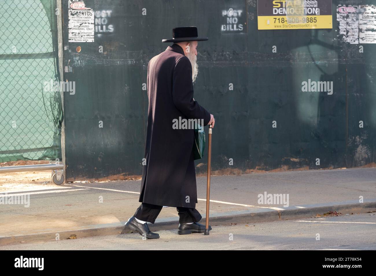 An older orthodox Jewish man with a long white beard walks in the ...