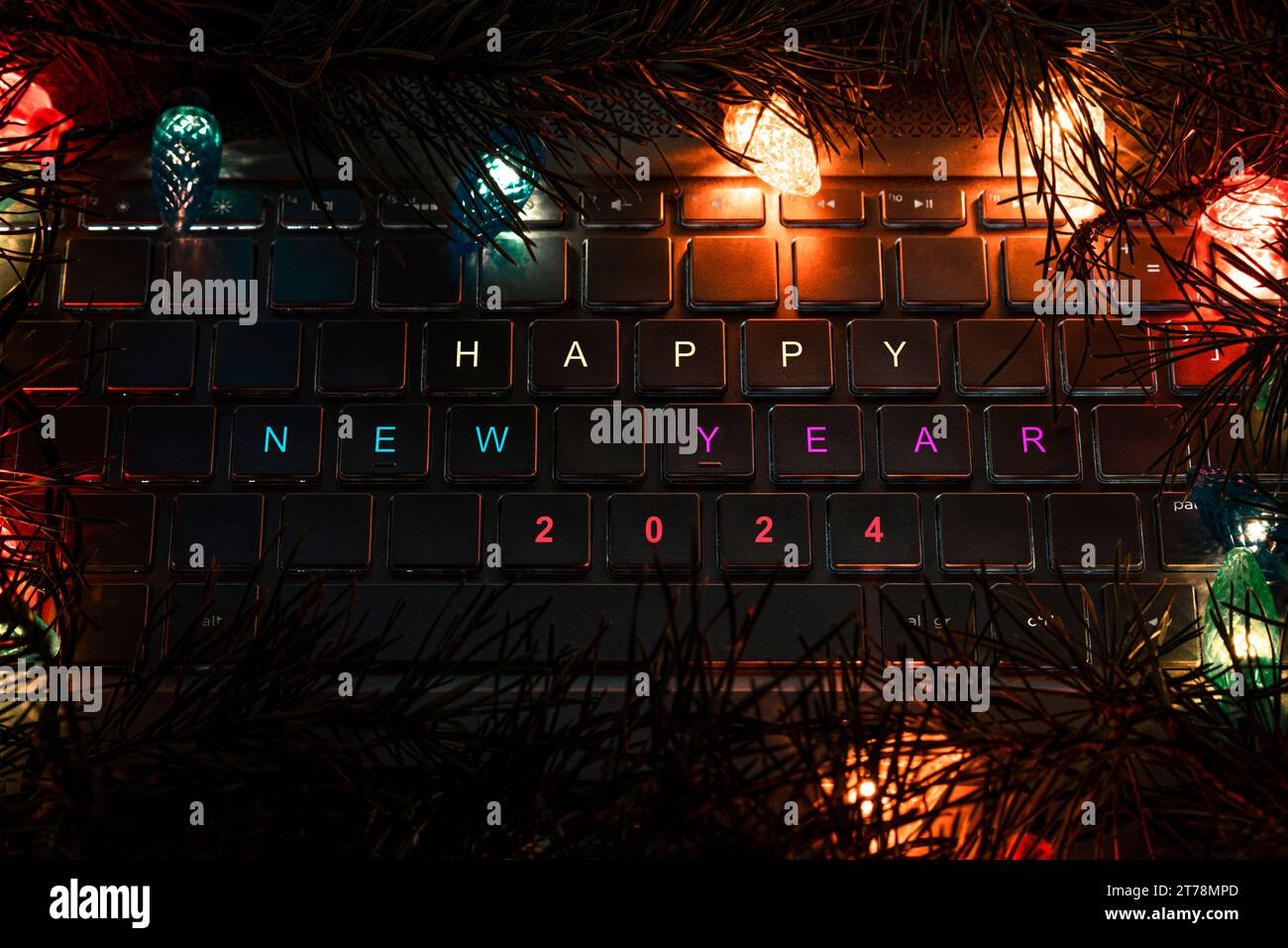 laptop keyboard surrounded by lights of a Christmas garland. Christmas ...