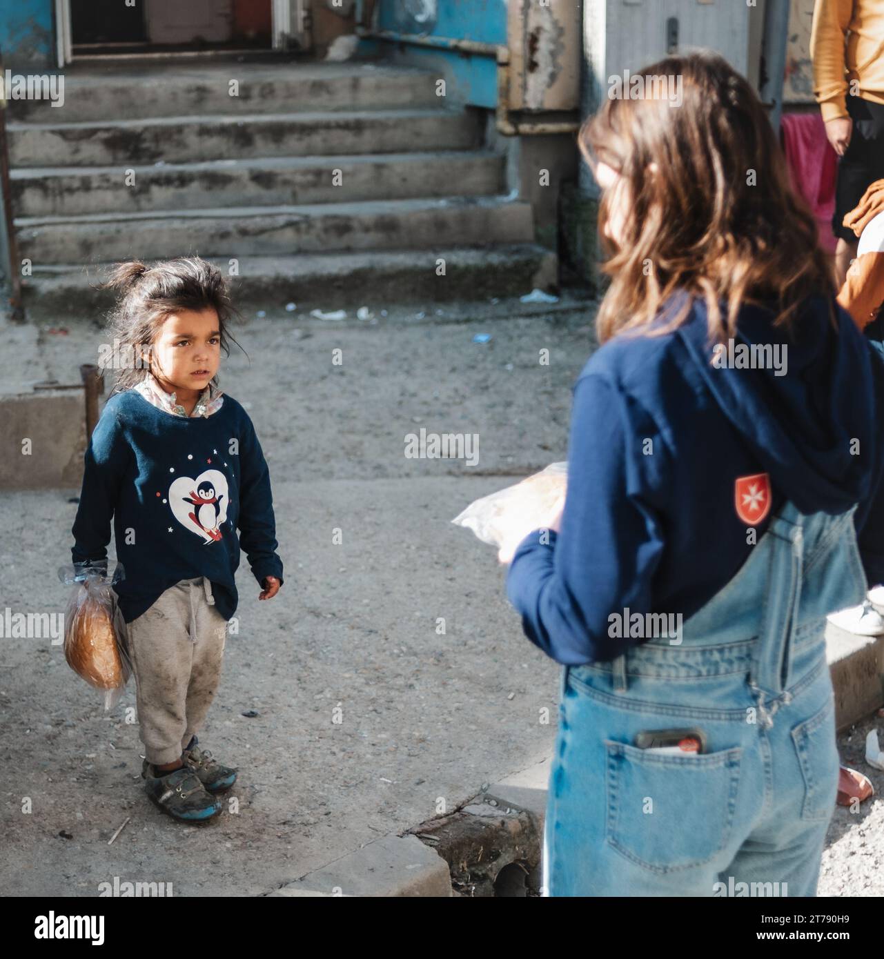 The poor gypsy kids getting bread from volunteers Stock Photo - Alamy