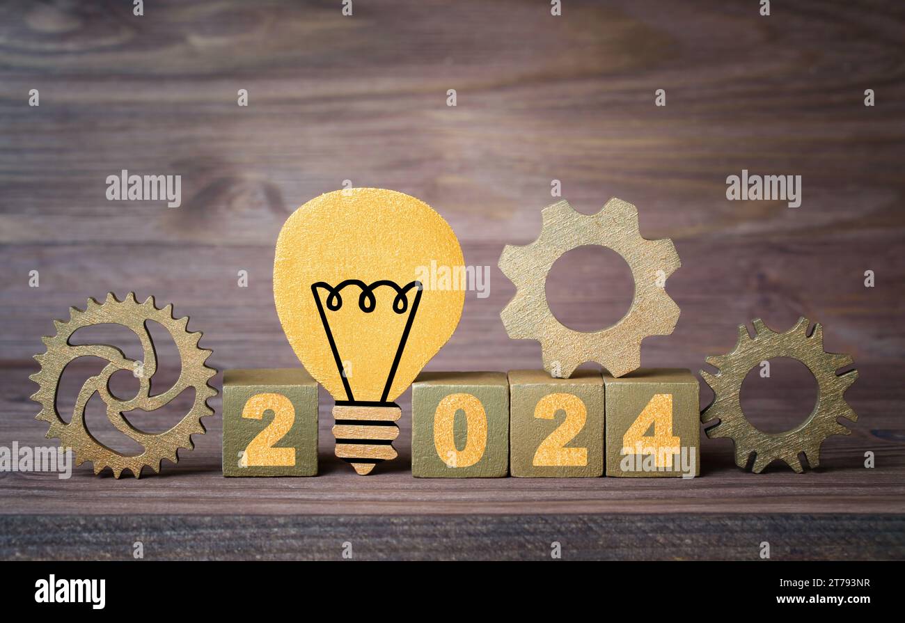 Wooden toy blocks reading 2024 with cogs, gears and a light bulb shape ...