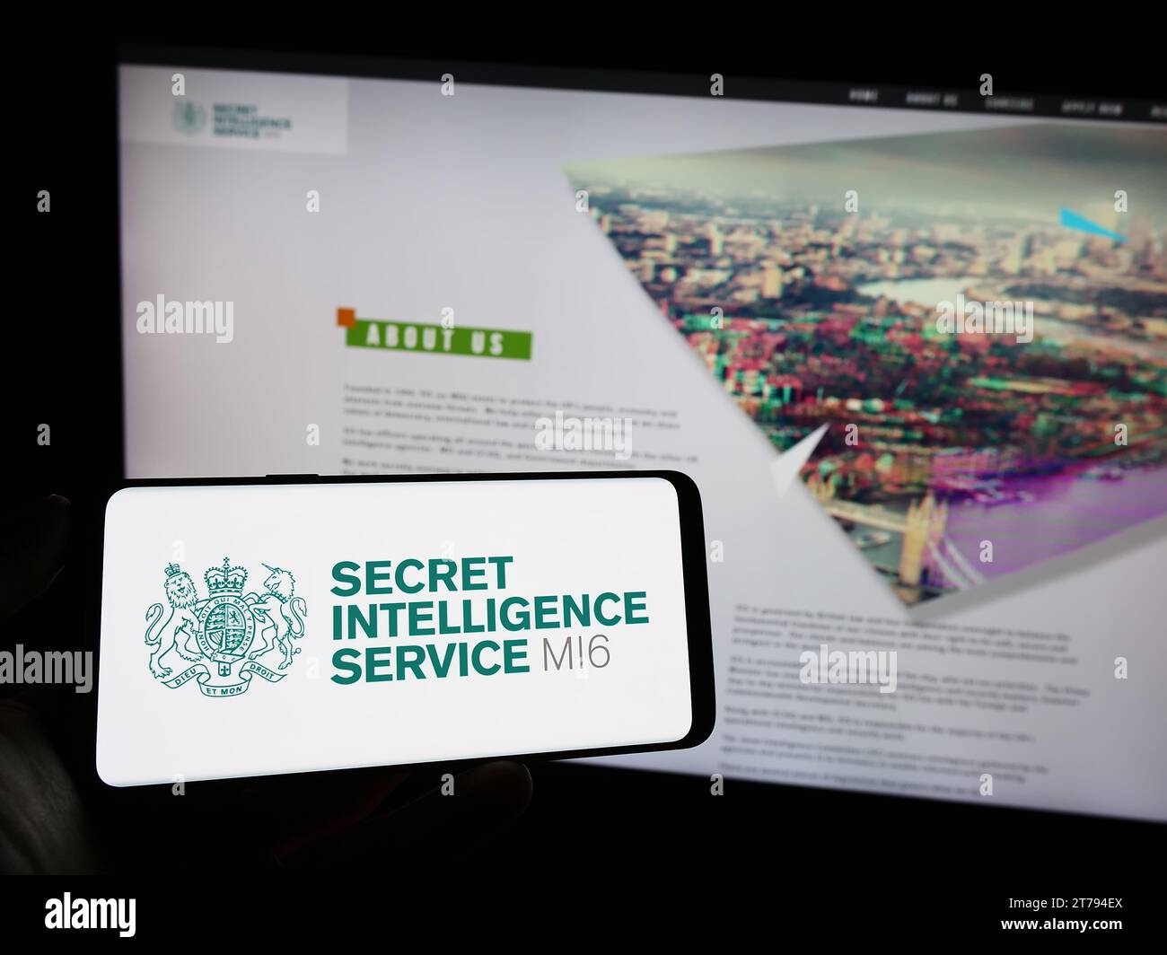 Person holding mobile phone with seal of British agency Secret Intelligence Service (SIS, MI6 ...