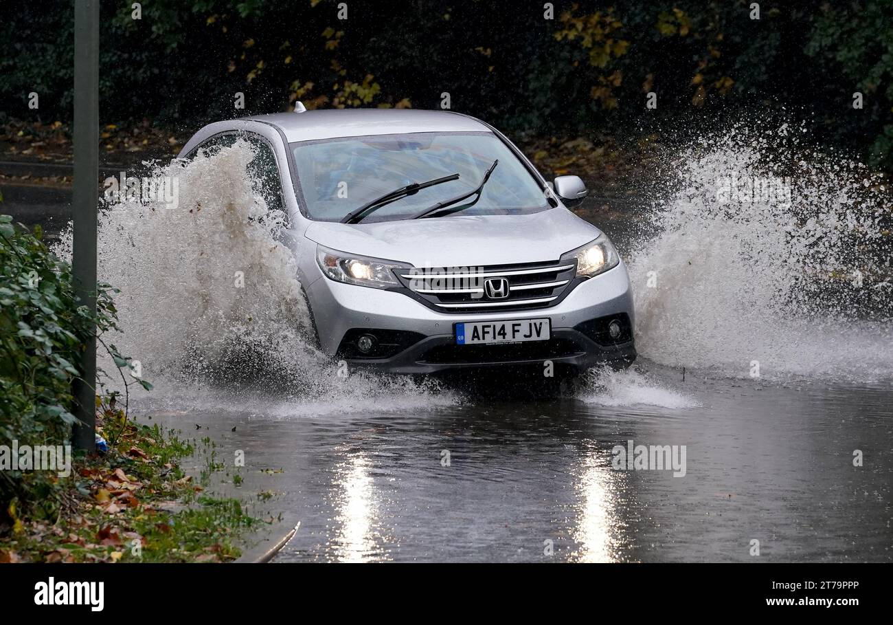 Cars pass through a flooded road in Ashford, Kent. A week's worth of ...