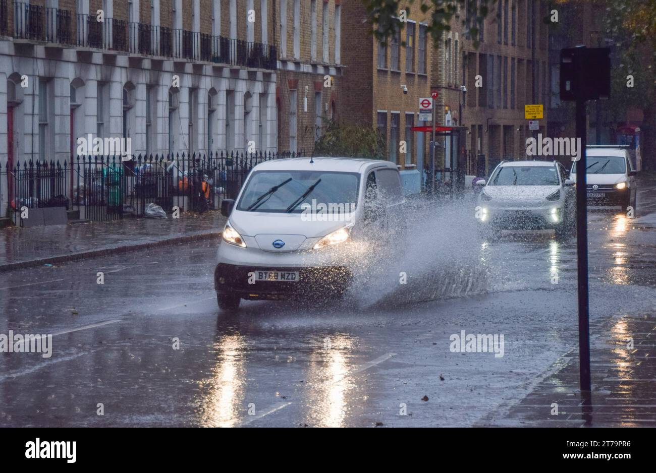 London, UK. 14th November 2023. A van splashes through a large puddle ...