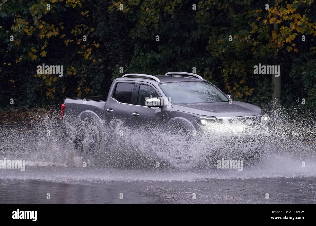 Cars pass through a flooded road in Ashford, Kent. A week's worth of ...