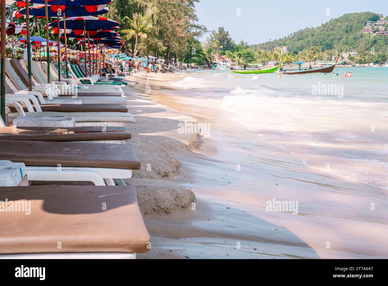 Empty sun lounge chairs under umbrellas standing close to seashore line ...
