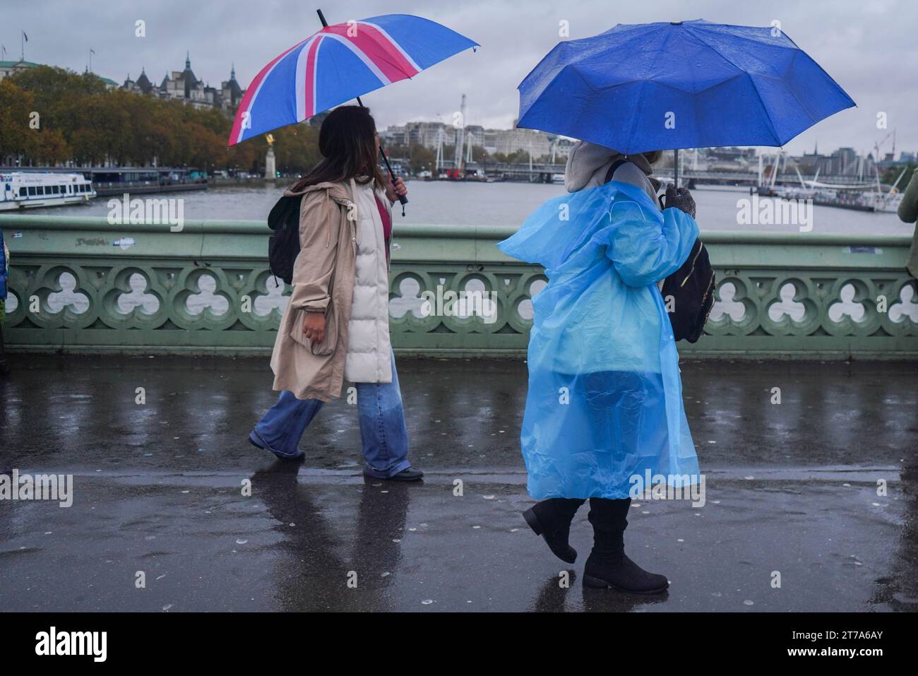 London, UK. 14 November 2023. Pedestrians with umbrellas on Westminster ...