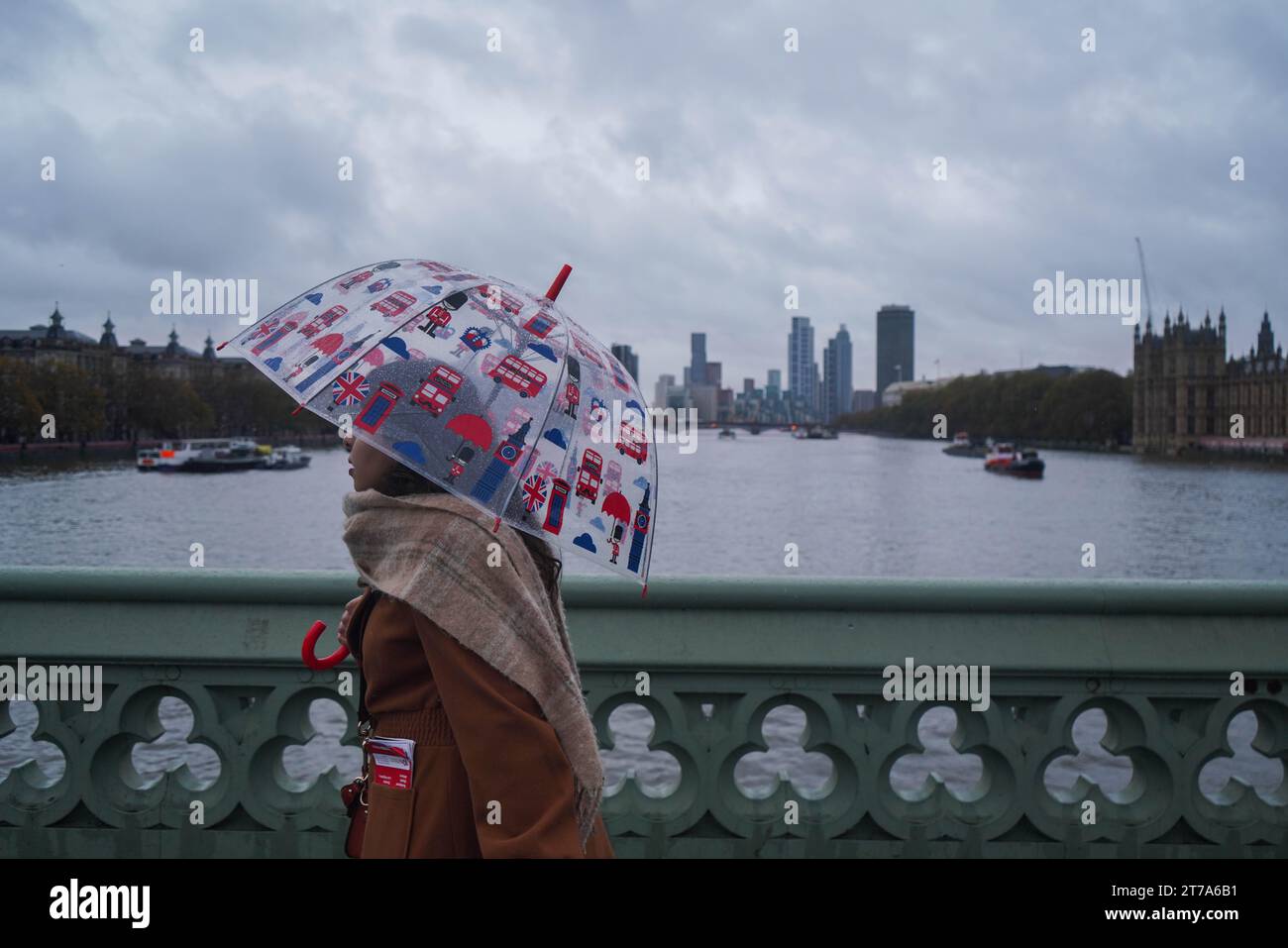 London, UK. 14 November 2023. Pedestrians with umbrellas on Westminster ...