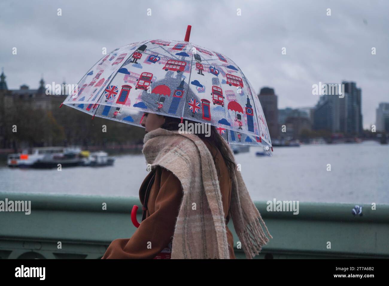 London, UK. 14 November 2023. Pedestrians with umbrellas on Westminster ...