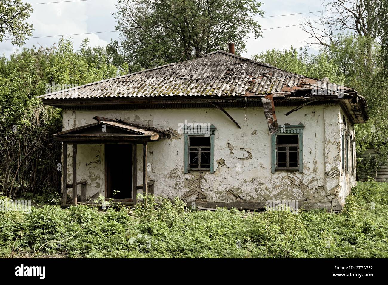 A photo of an old, dilapidated house with a crumbling roof and overgrown vegetation Stock Photo ...