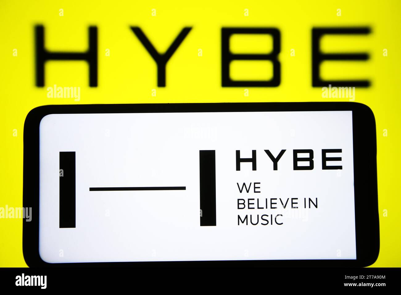 In this photo illustration, HYBE logo is seen on a smartphone and on a ...