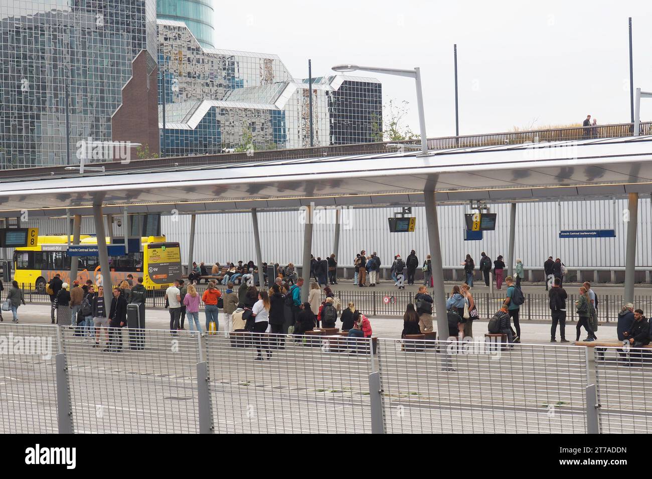 Large bus station, yellow bus with group of people waiting at Utrecht ...