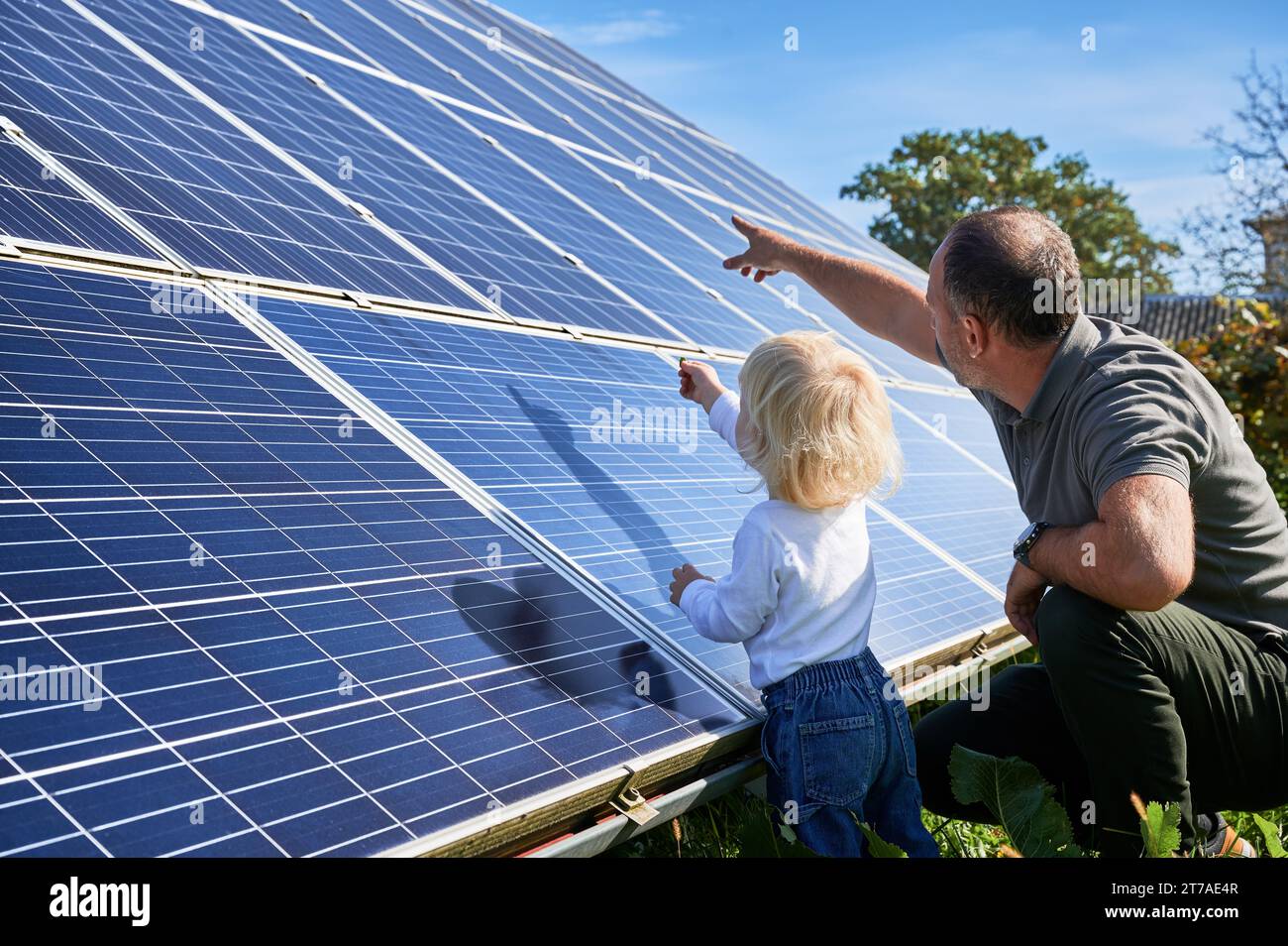 Man showing his small kid solar panels during sunny day. Father ...