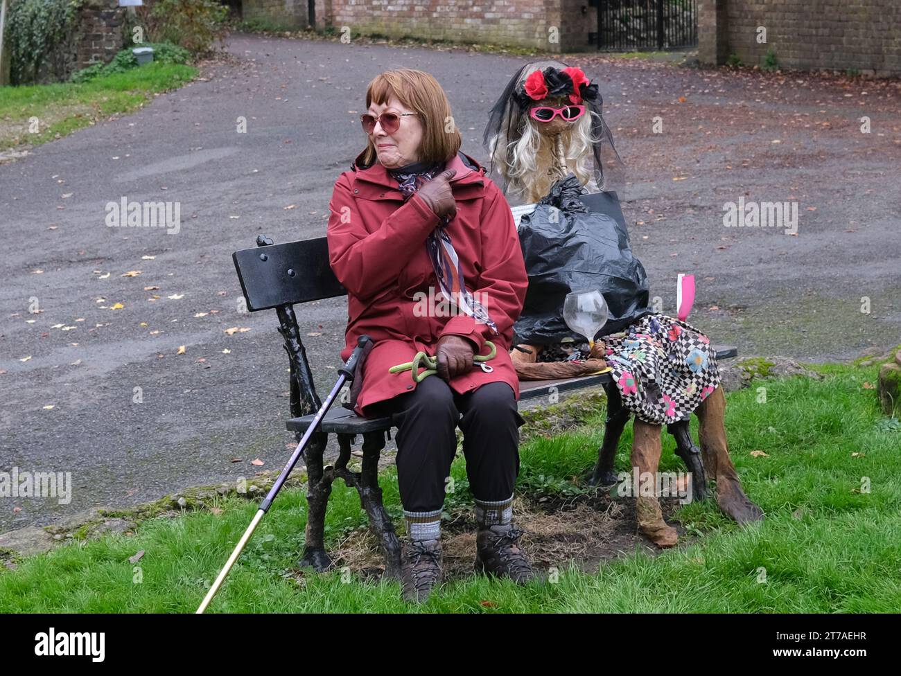 Woman sitting next to Halloween dummy scarecrow on Halloween trail in ...
