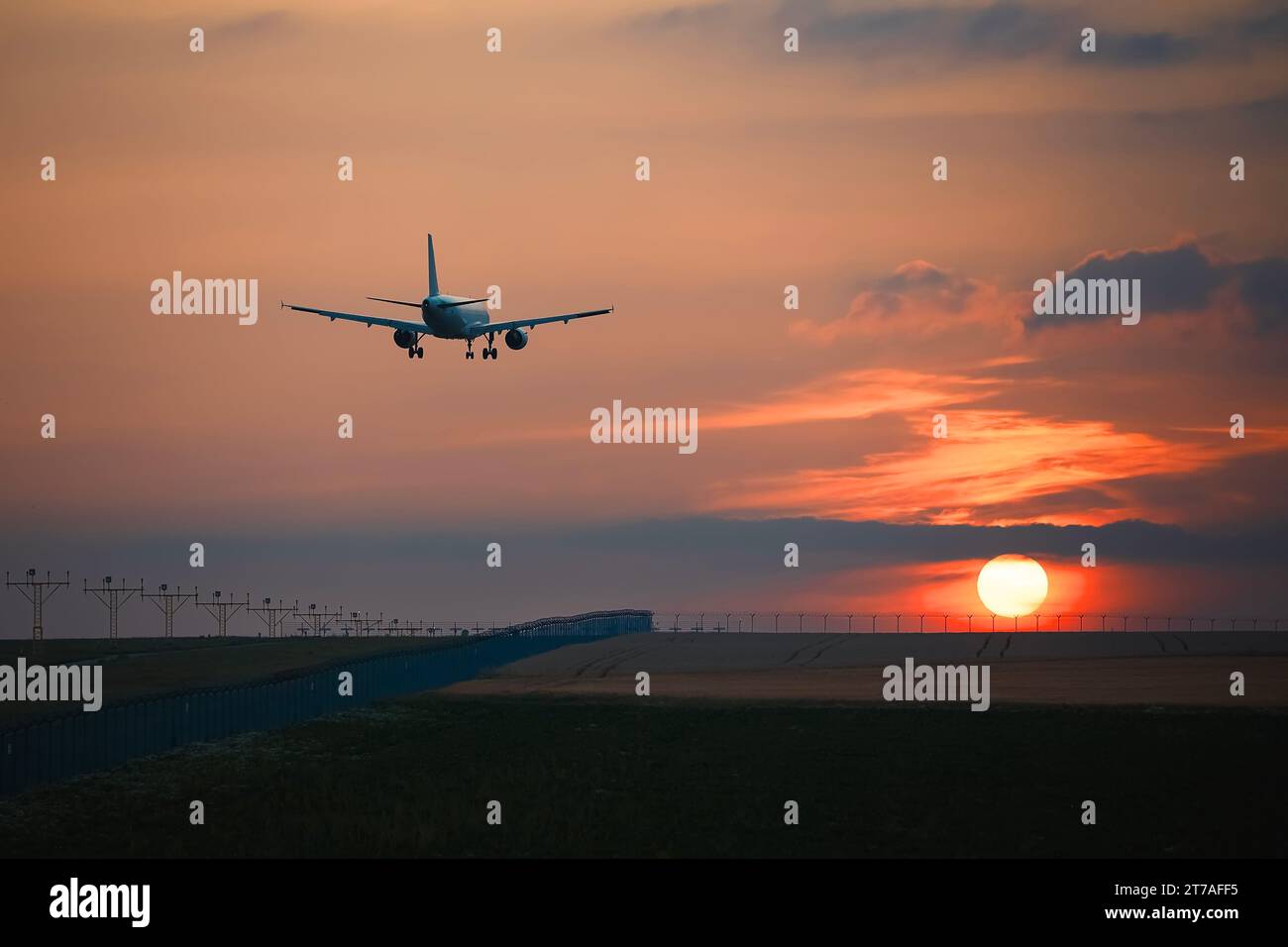 Airplane landing on airport runway at beautiful sunset. Themes travel ...
