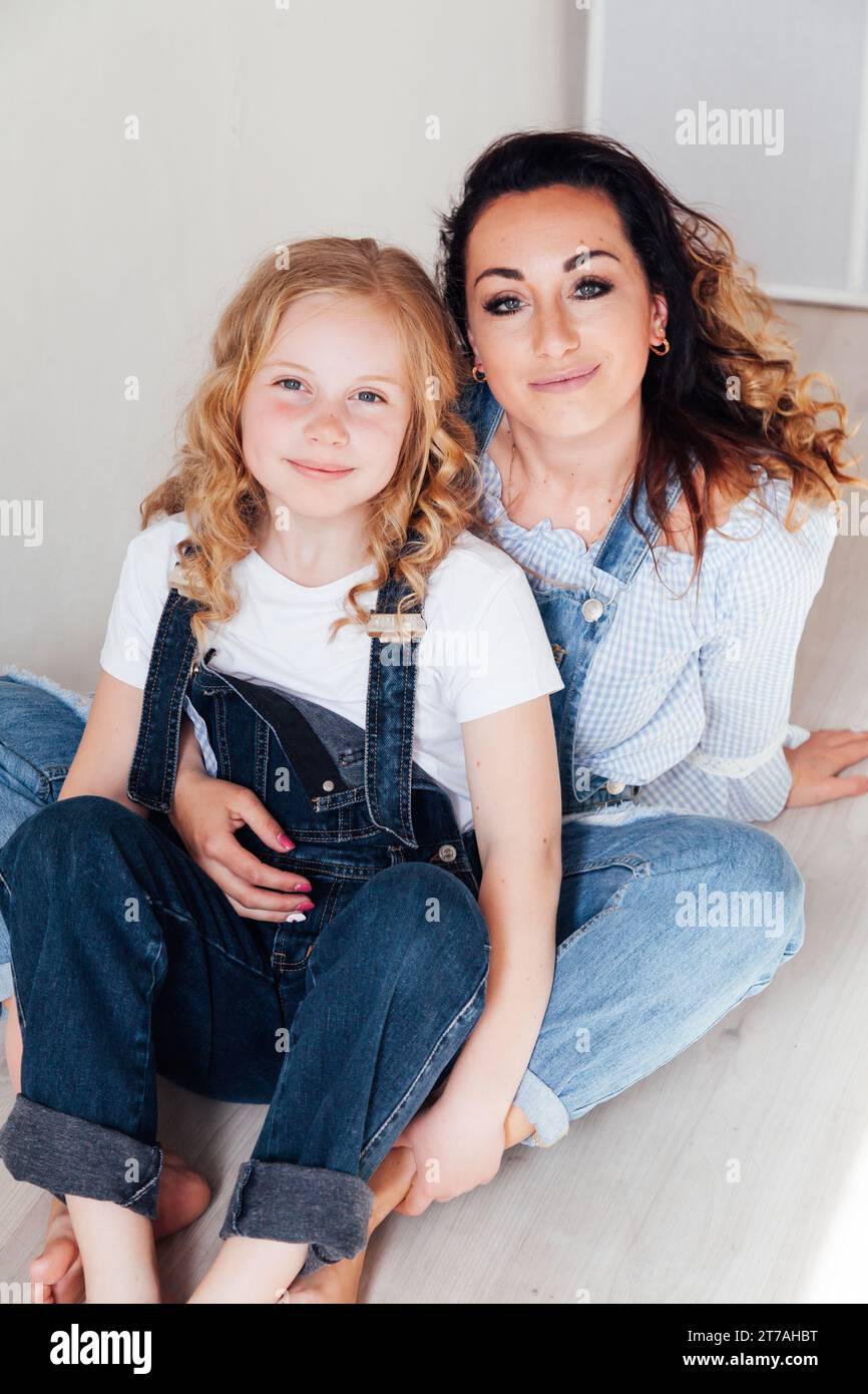 mother and daughter family look sitting on the floor in a hug Stock ...