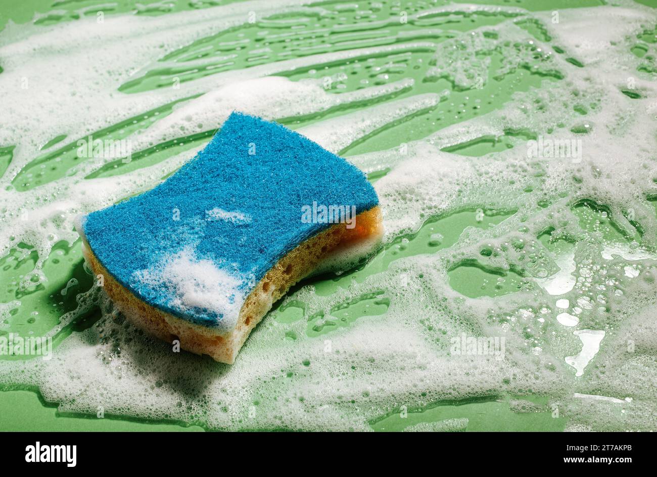 cleaning sponge wiping foam soap suds on blue background, household ...