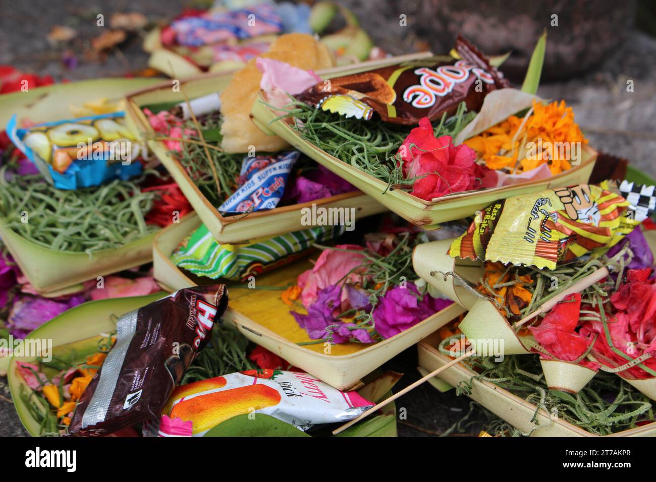 Religious offering of food and flowers in baskets made of banana leaves ...