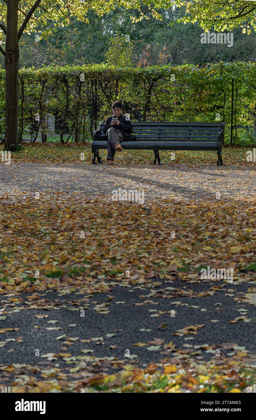 London, UK - Nov 05, 2023 - Young man sitting alone on the bench in the ...