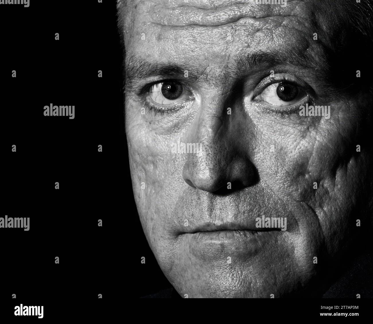 Low key portrait of an elder man with a vulnerable, fearful expression ...