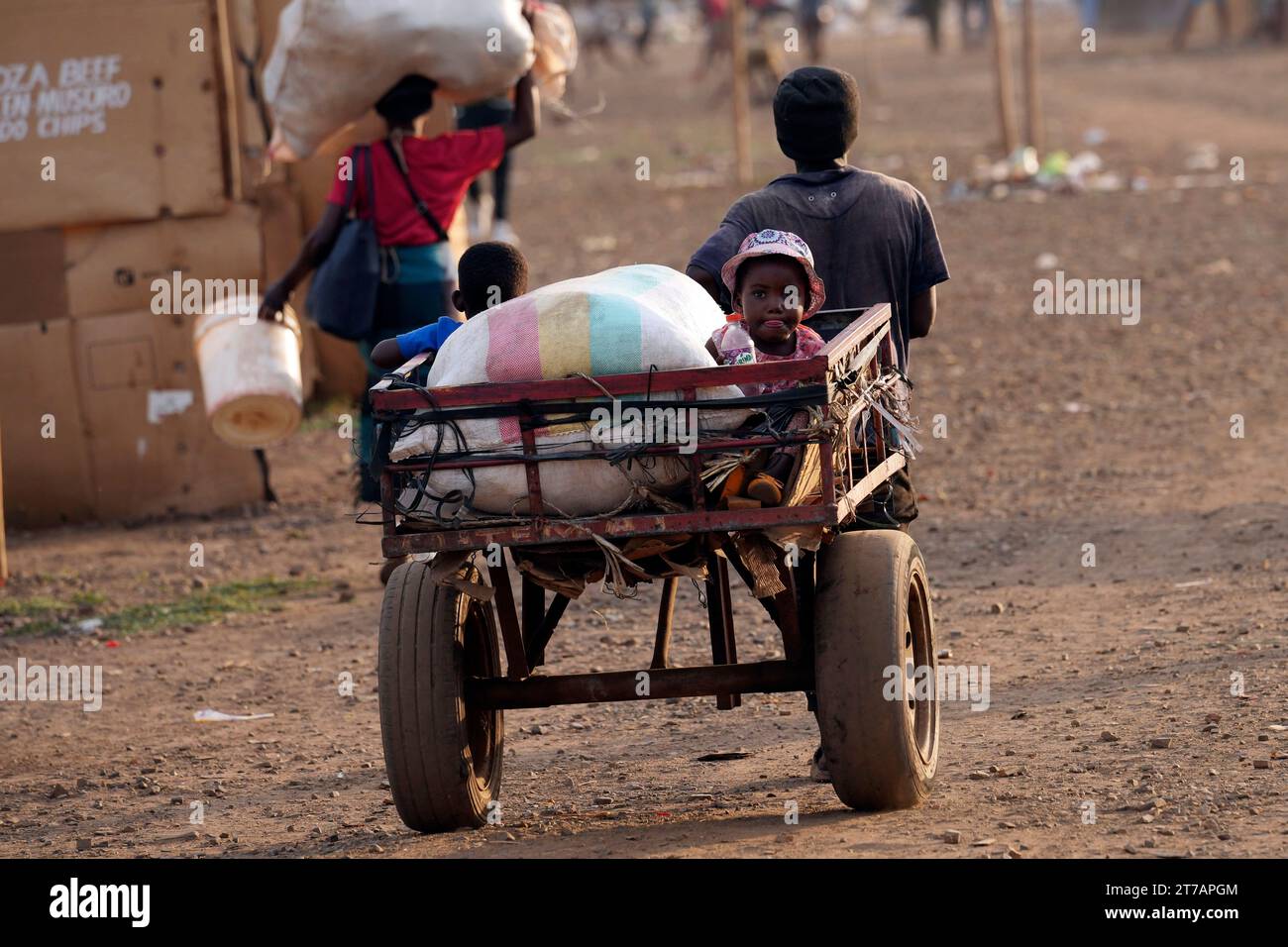 Children are transported using a push cart in Mbare, a poor ...