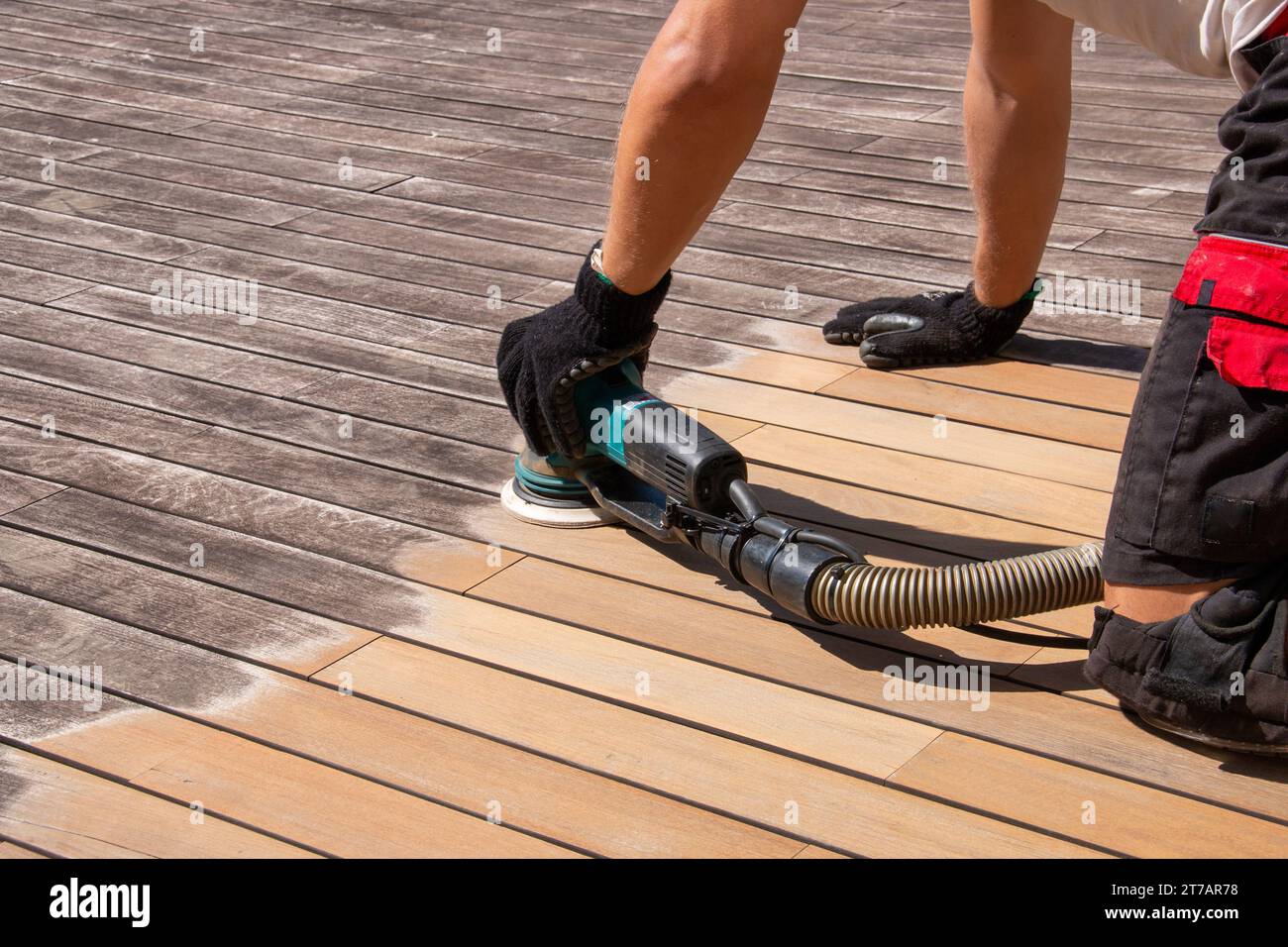 Deck builder sanding grey patina out of weathered ipe wood boards Stock ...