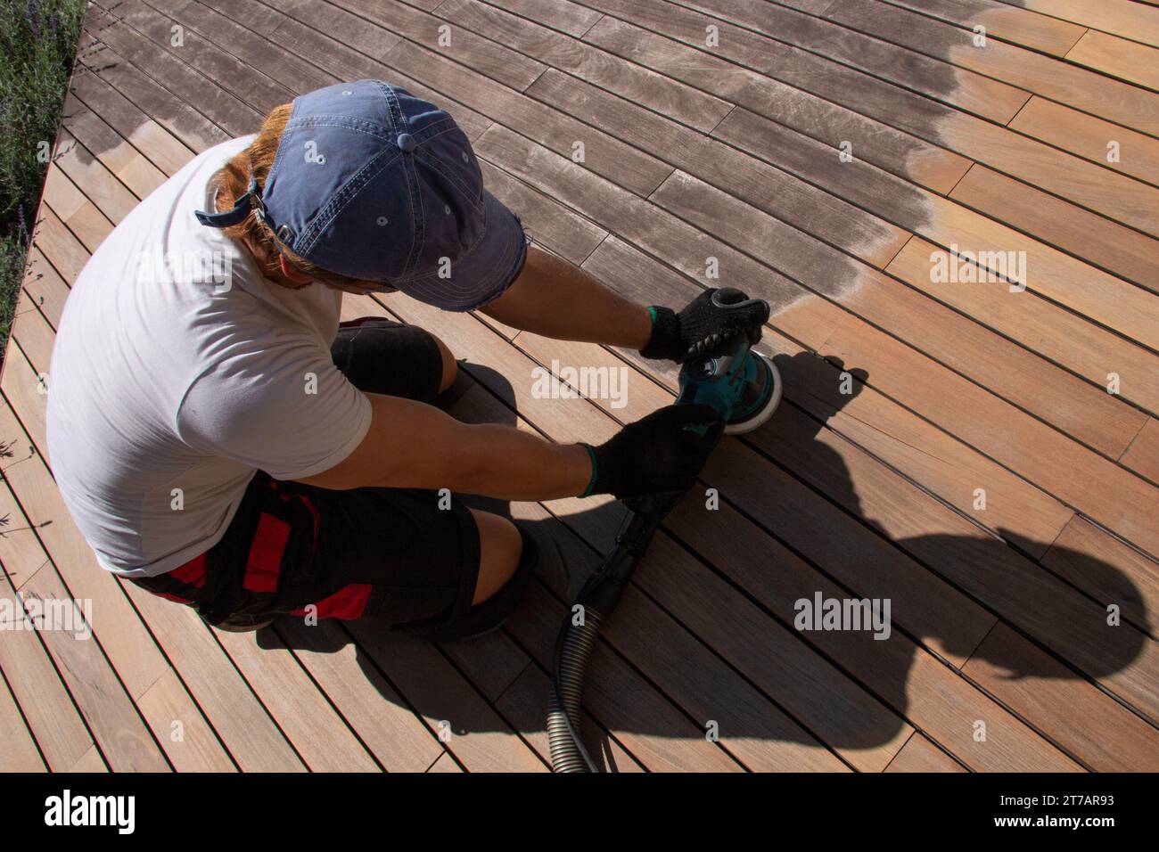Man sanding and cleaning wooden deck with the power sander Stock Photo ...