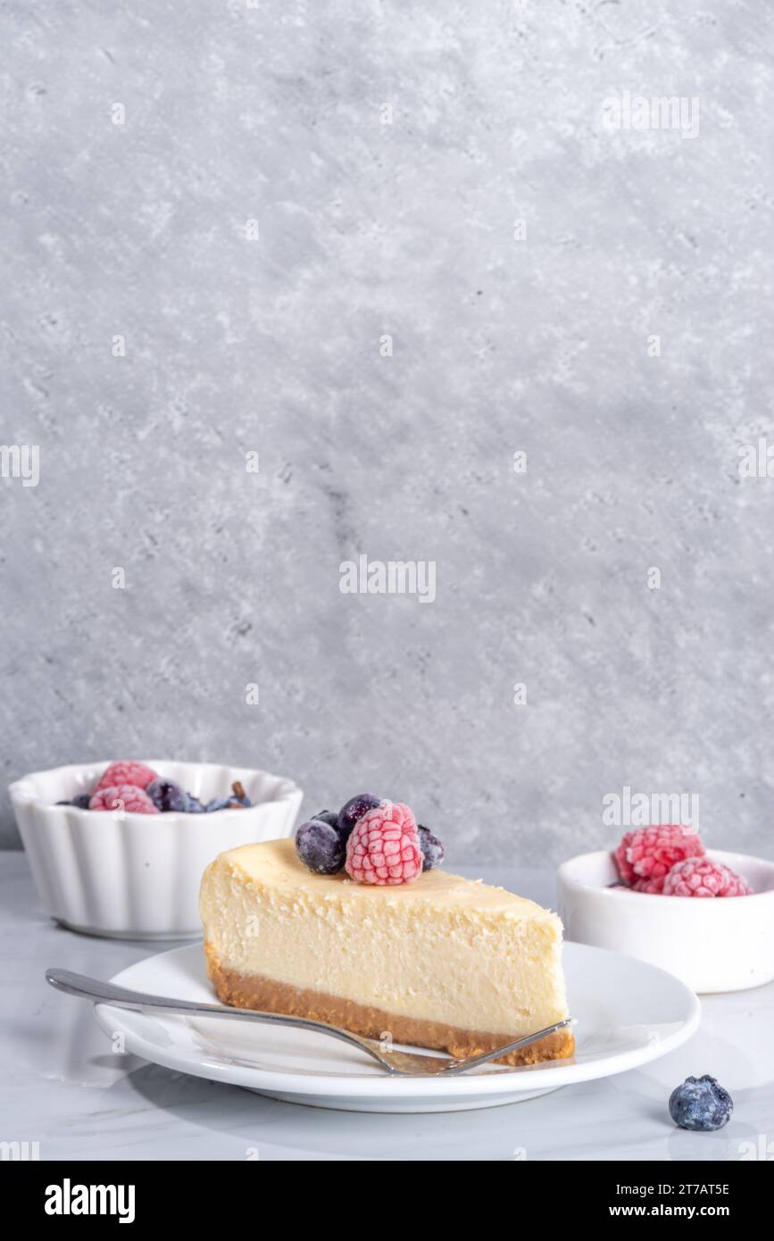 Cheesecake portion slice on plate, with raspberry on blueberry on white ...