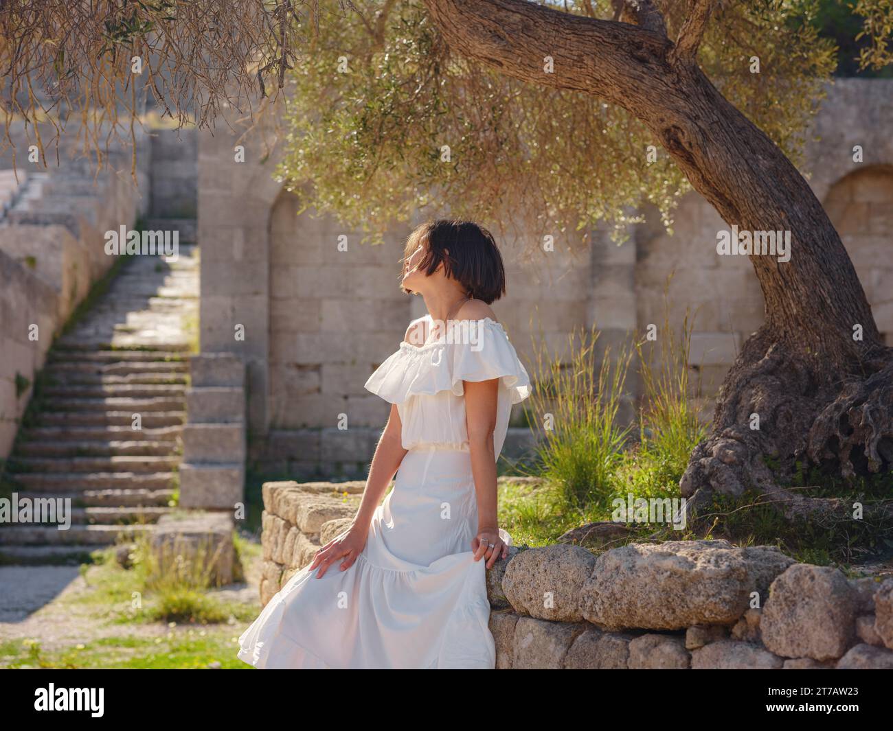 Beautiful Asian young woman in white dress outdoor. Acropolis of Rhodes ...