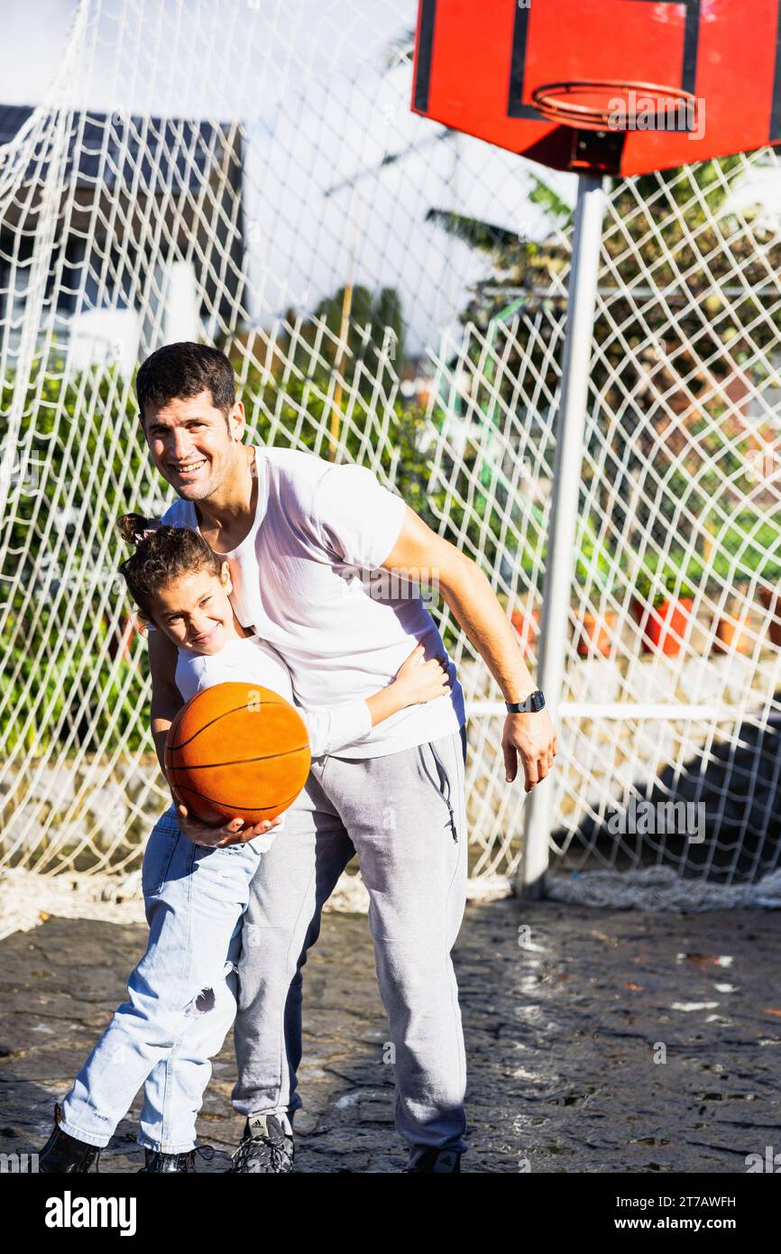 Father and daughter hugging smiling with basketball, vertical photo ...